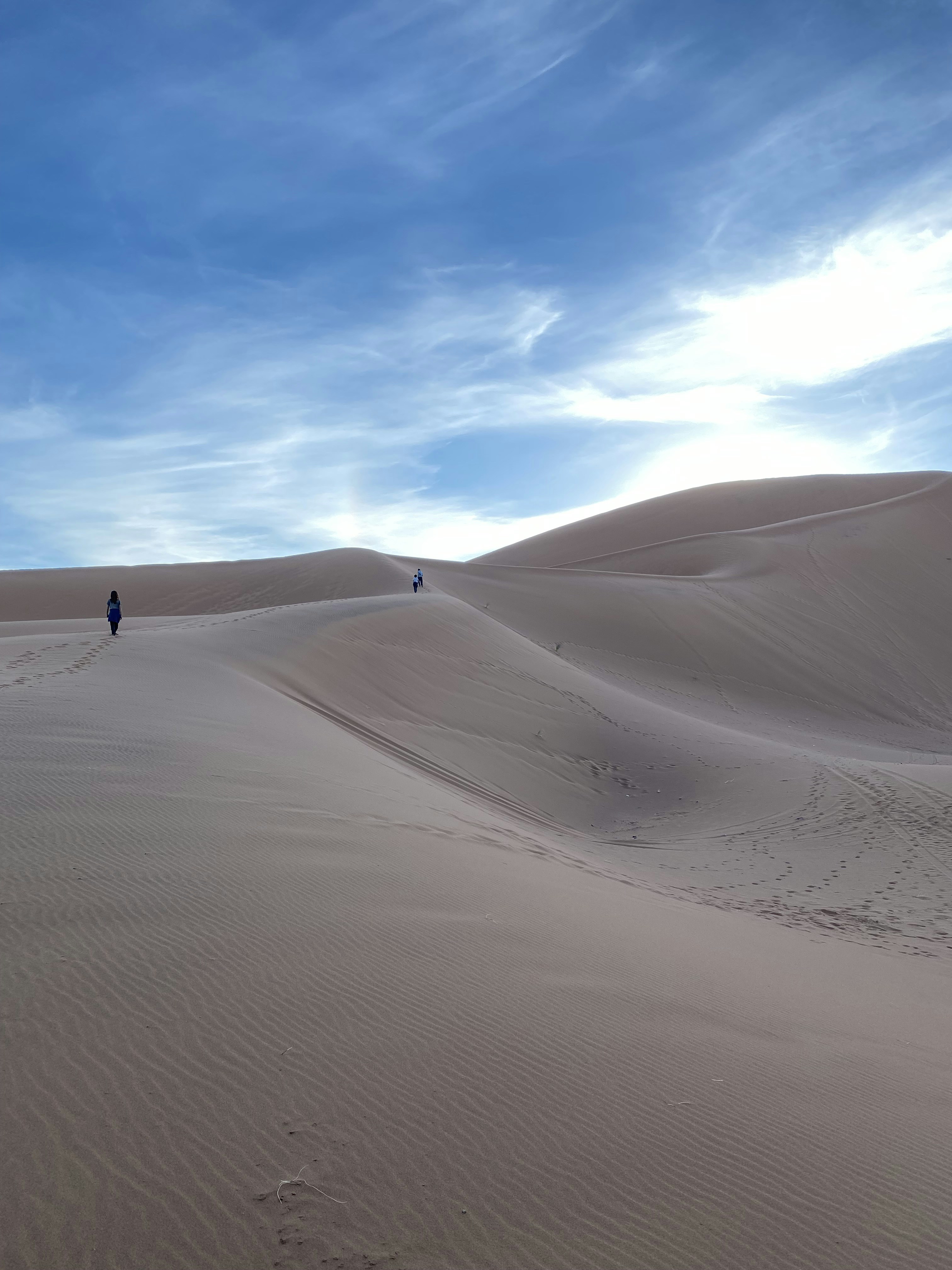 A person walking across a sandy field under a blue sky photo – Free M ...