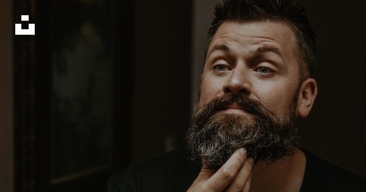 A Man Is Shaving His Beard In The Mirror Photo Free Portrait Image On