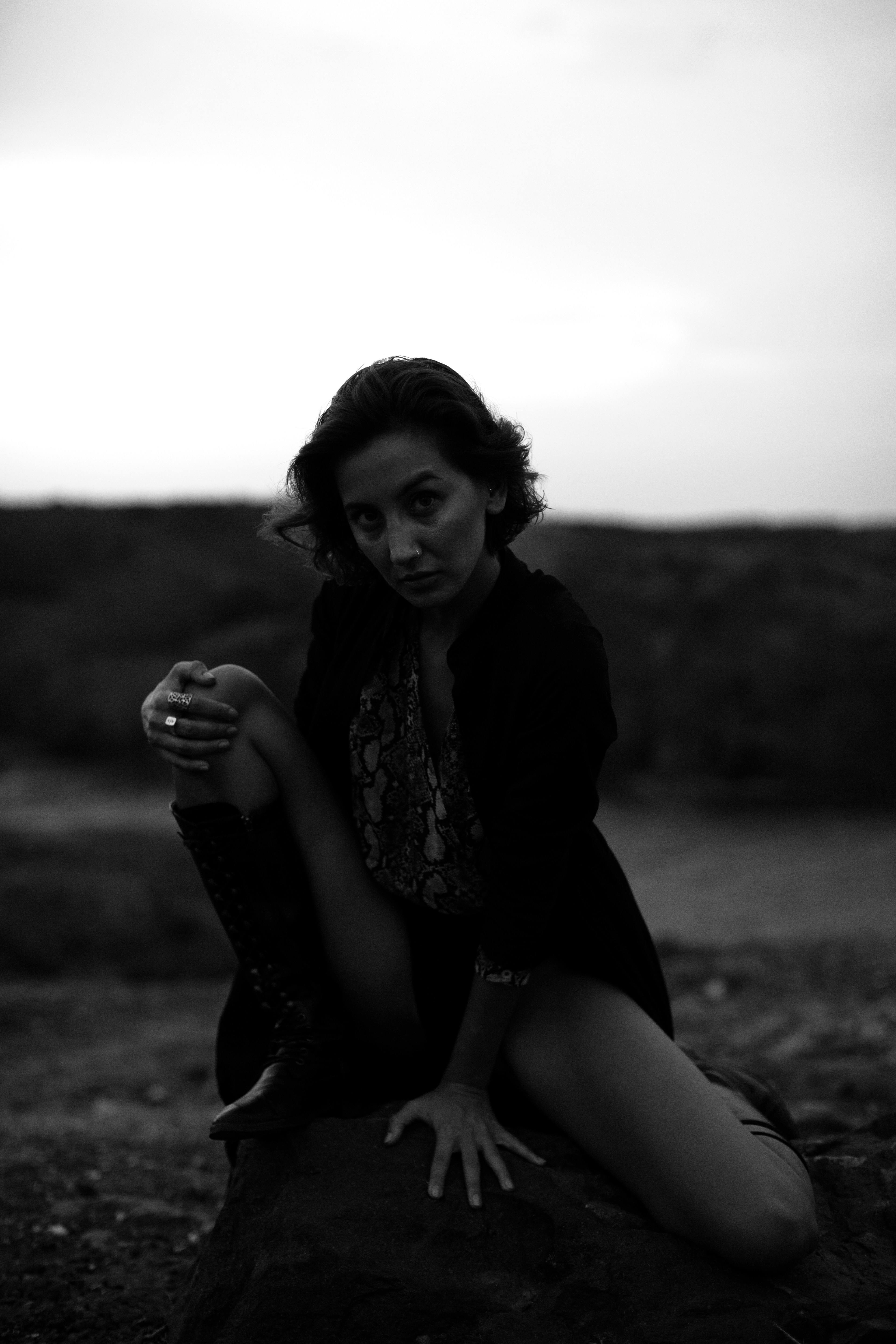 A woman sitting on a rock in the middle of a field photo – Free Woman ...