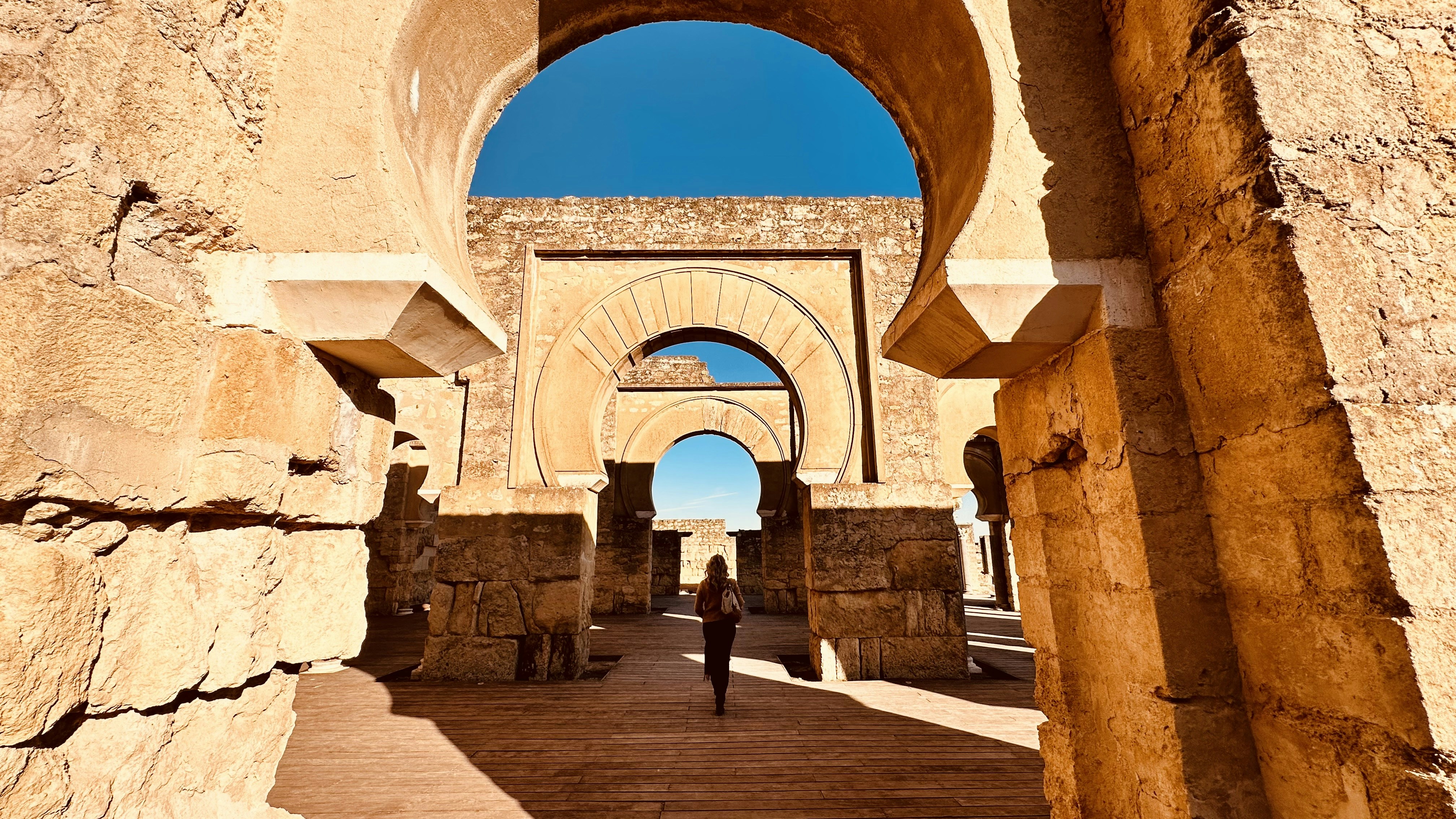 A person standing in an archway between two buildings photo – Free Arch ...