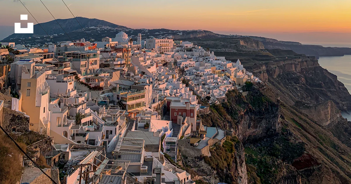 A View Of A Town On A Cliff Overlooking A Body Of Water Photo Free a-view-of-a-town-on-a-cliff-overlooking-a-body-of-water-photo-free