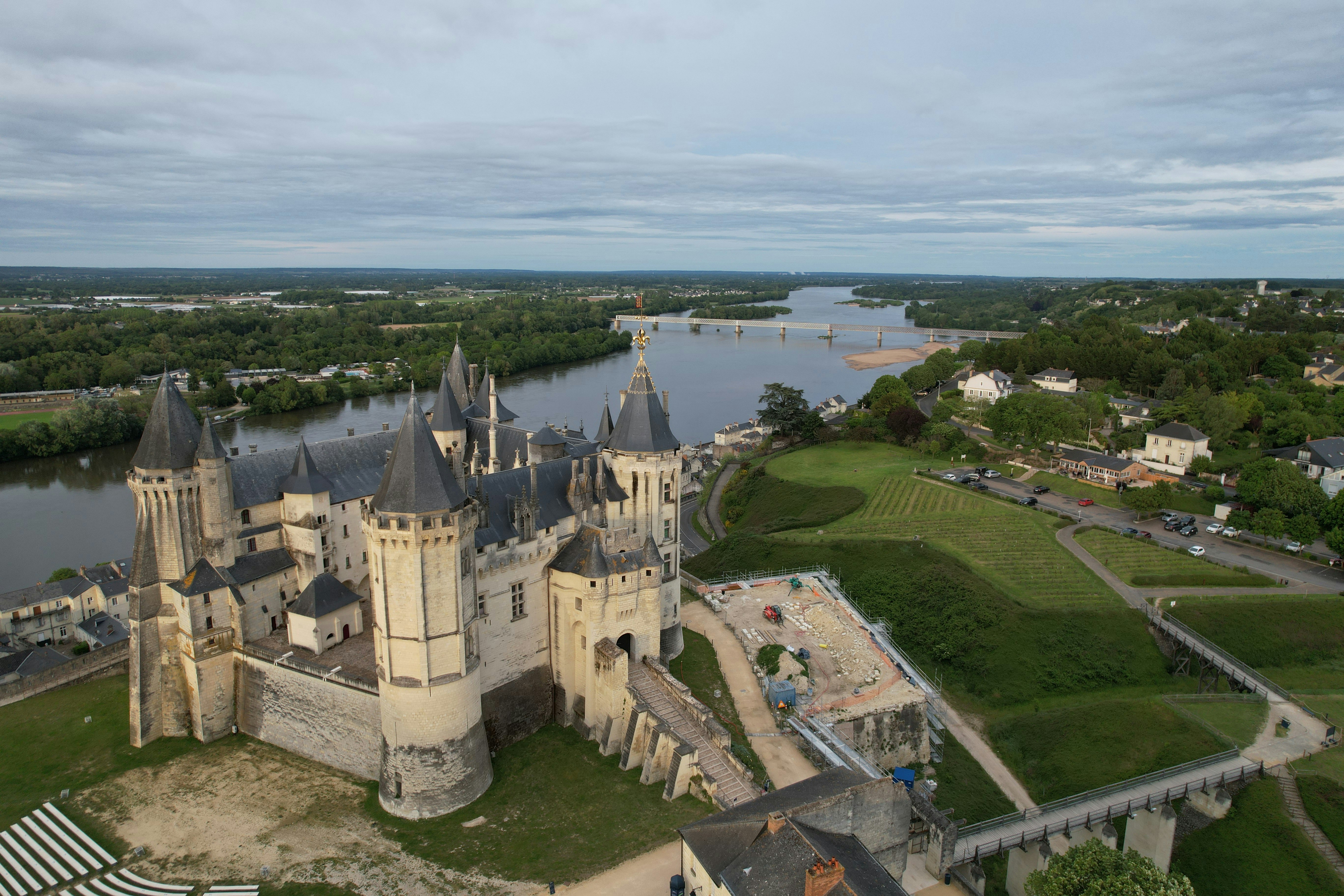 an aerial view of a castle with a river in the background