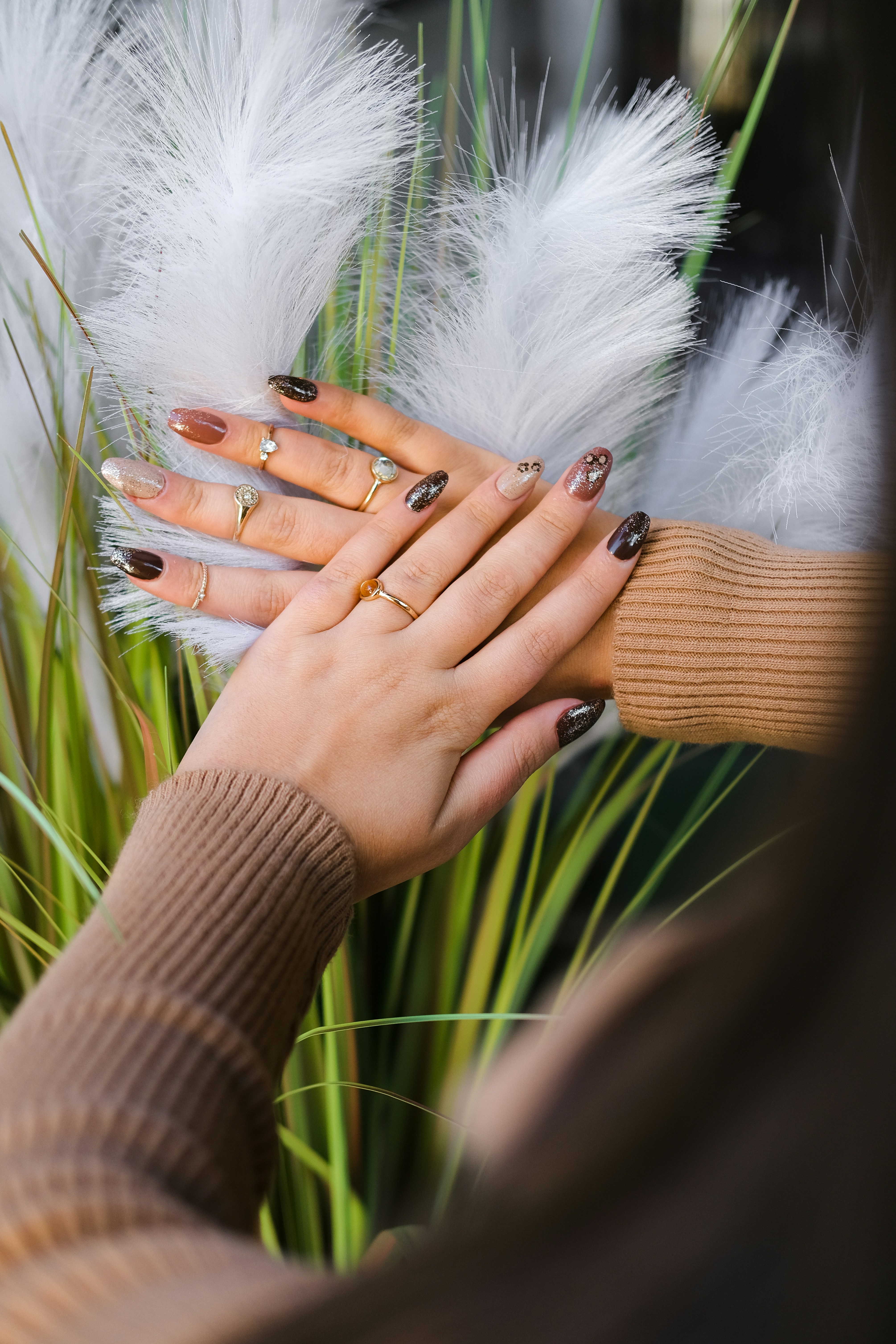 Hands in Harmony: A Close Encounter with Soft Feathers and Autumn Nails