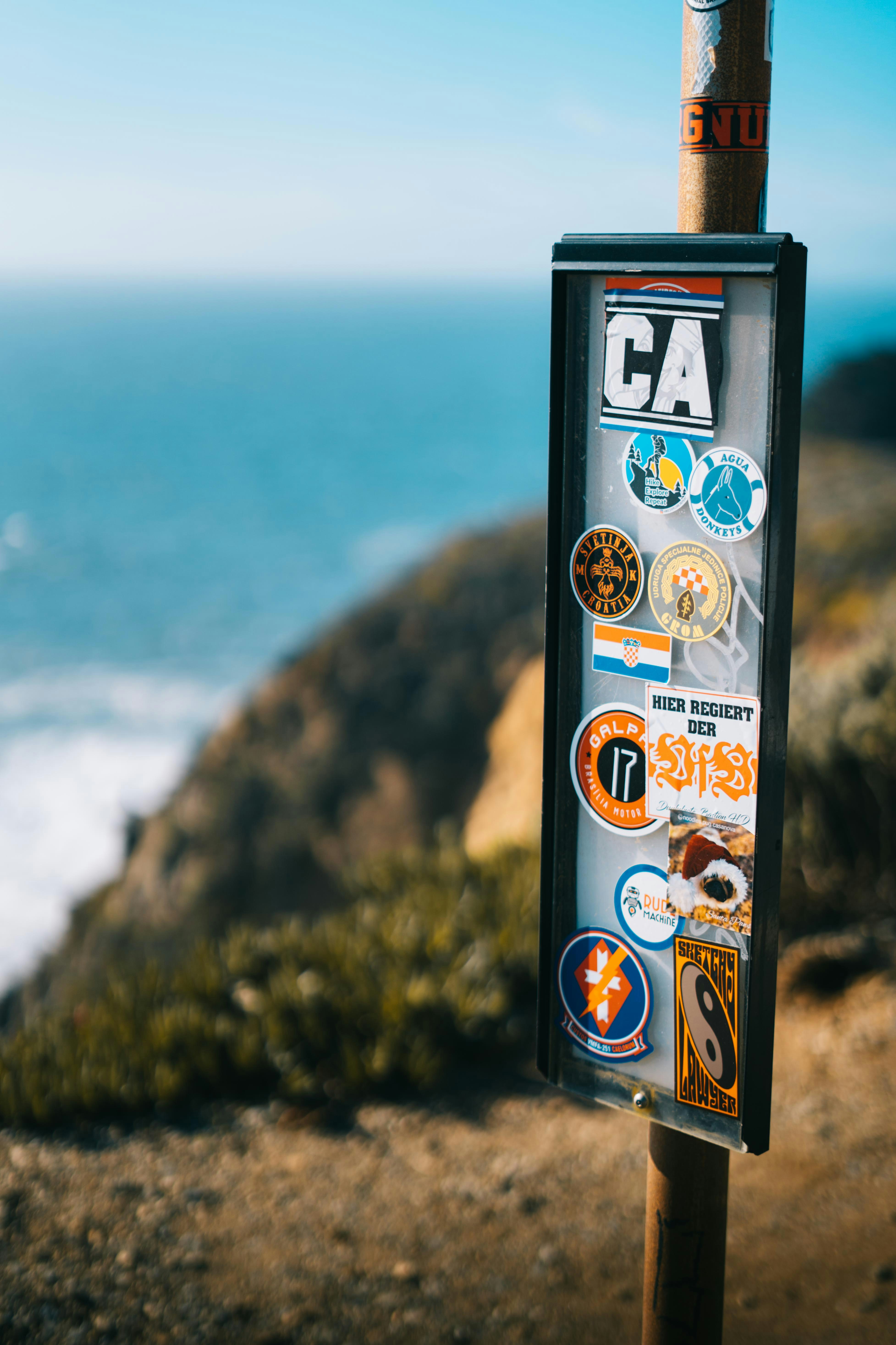 Stickers on a Cliffside Signpost: A Sea-Blue Frame