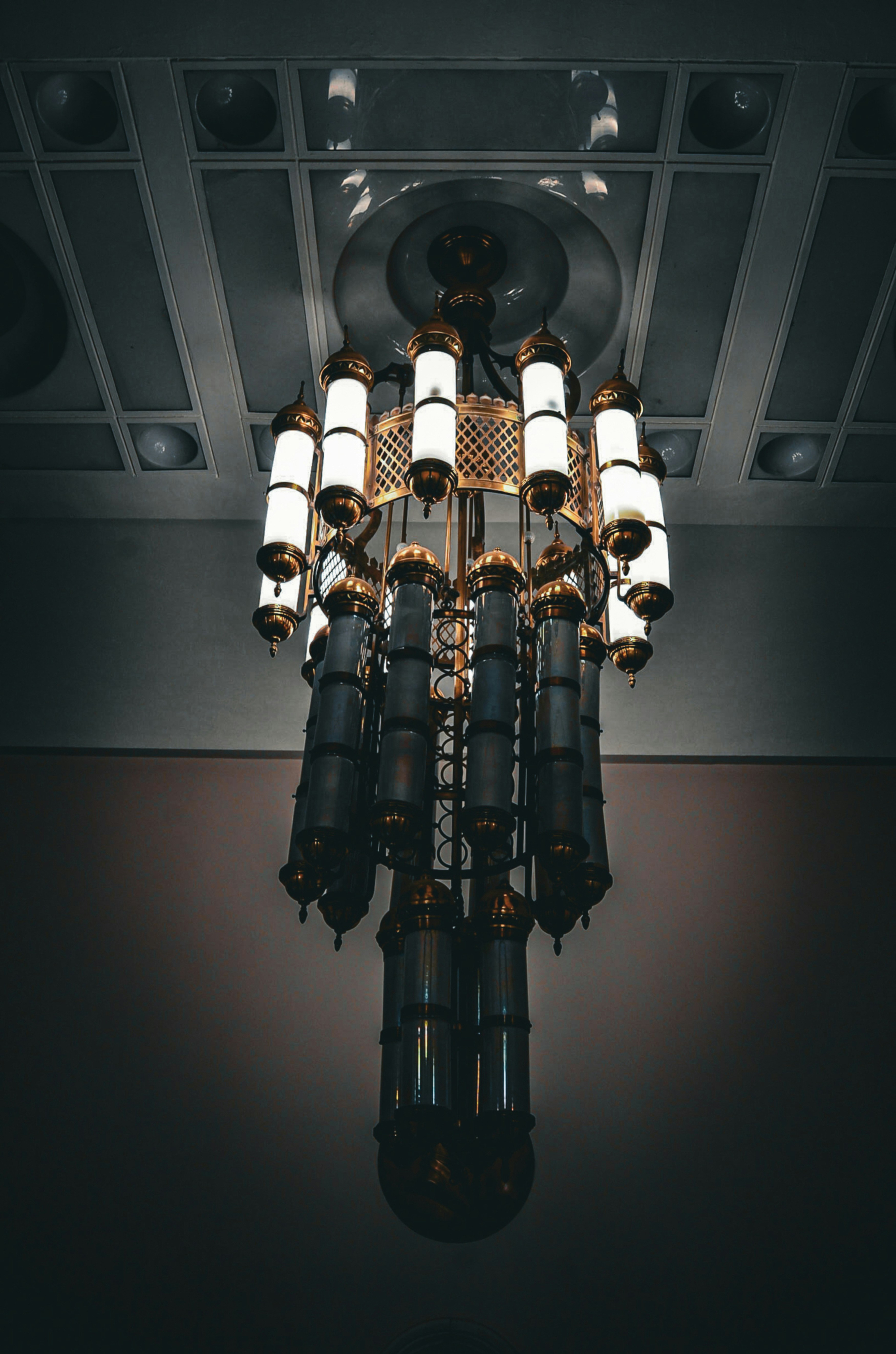 Geometric Glow: A Vintage Chandelier in a Grid Ceiling