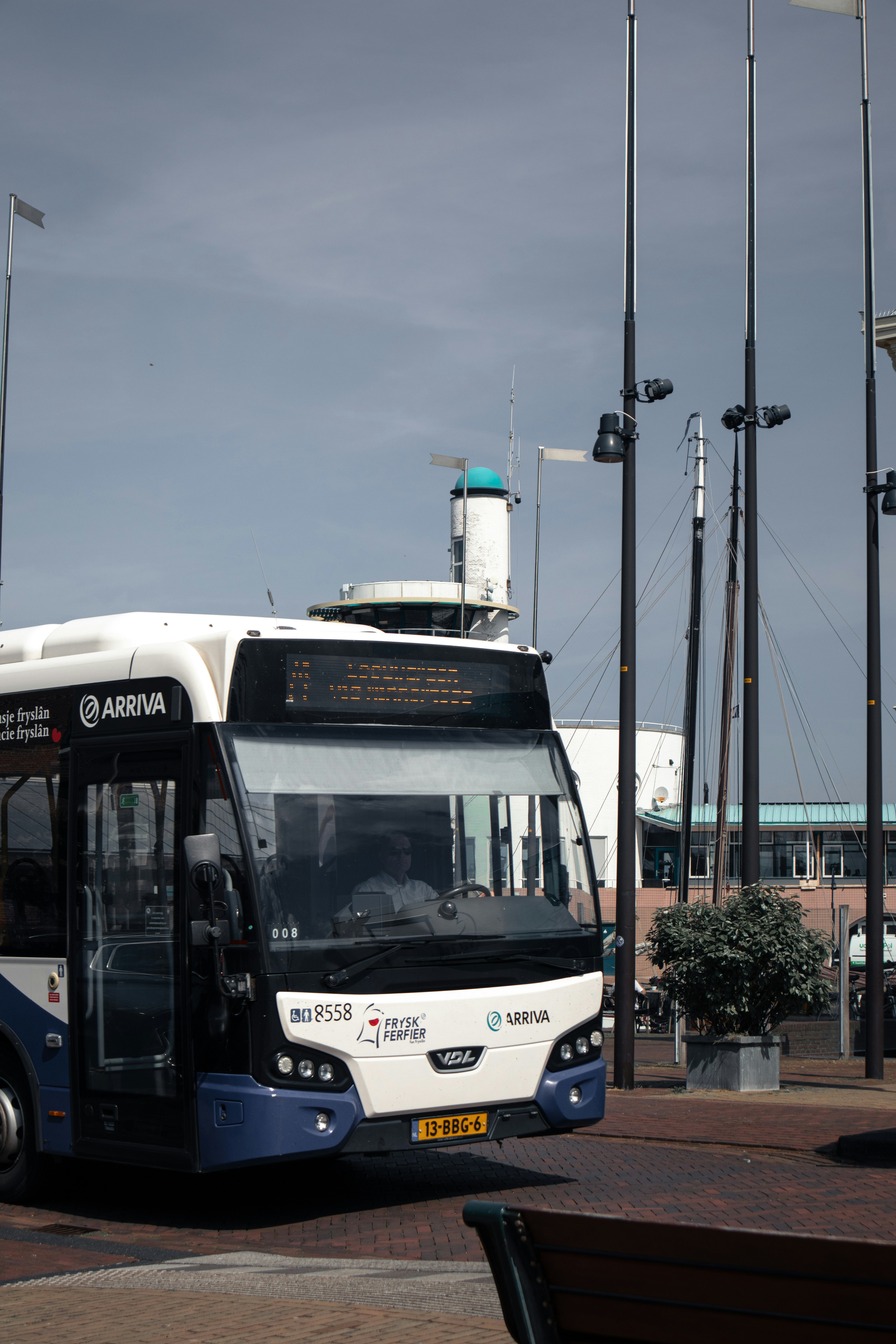 Harborbound Arrival: An Arriva Bus at a Dockside Terminal Framed by Mast-Pole Light