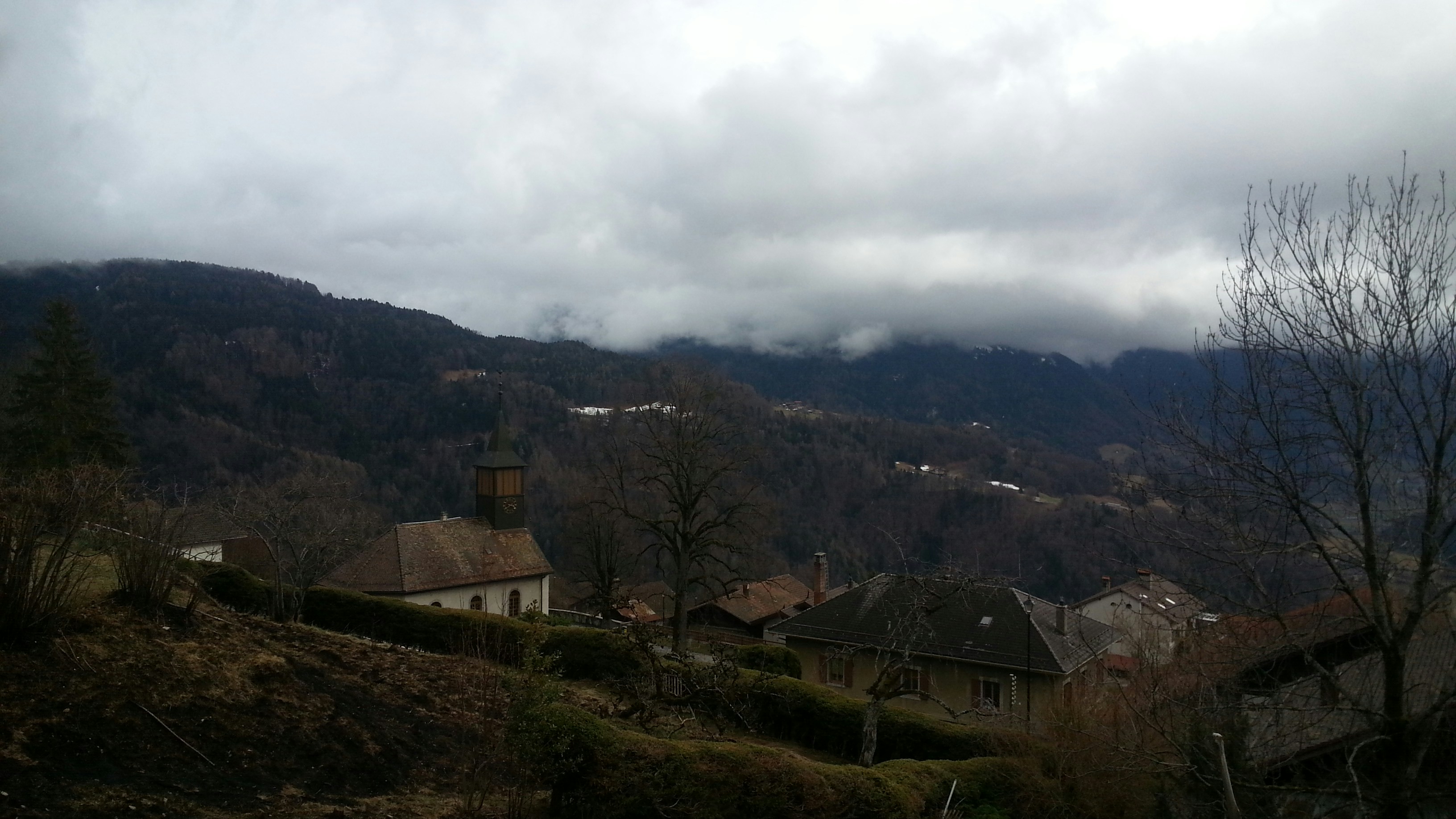 Hushed Valley Hamlet Beneath a Looming Cloudscape