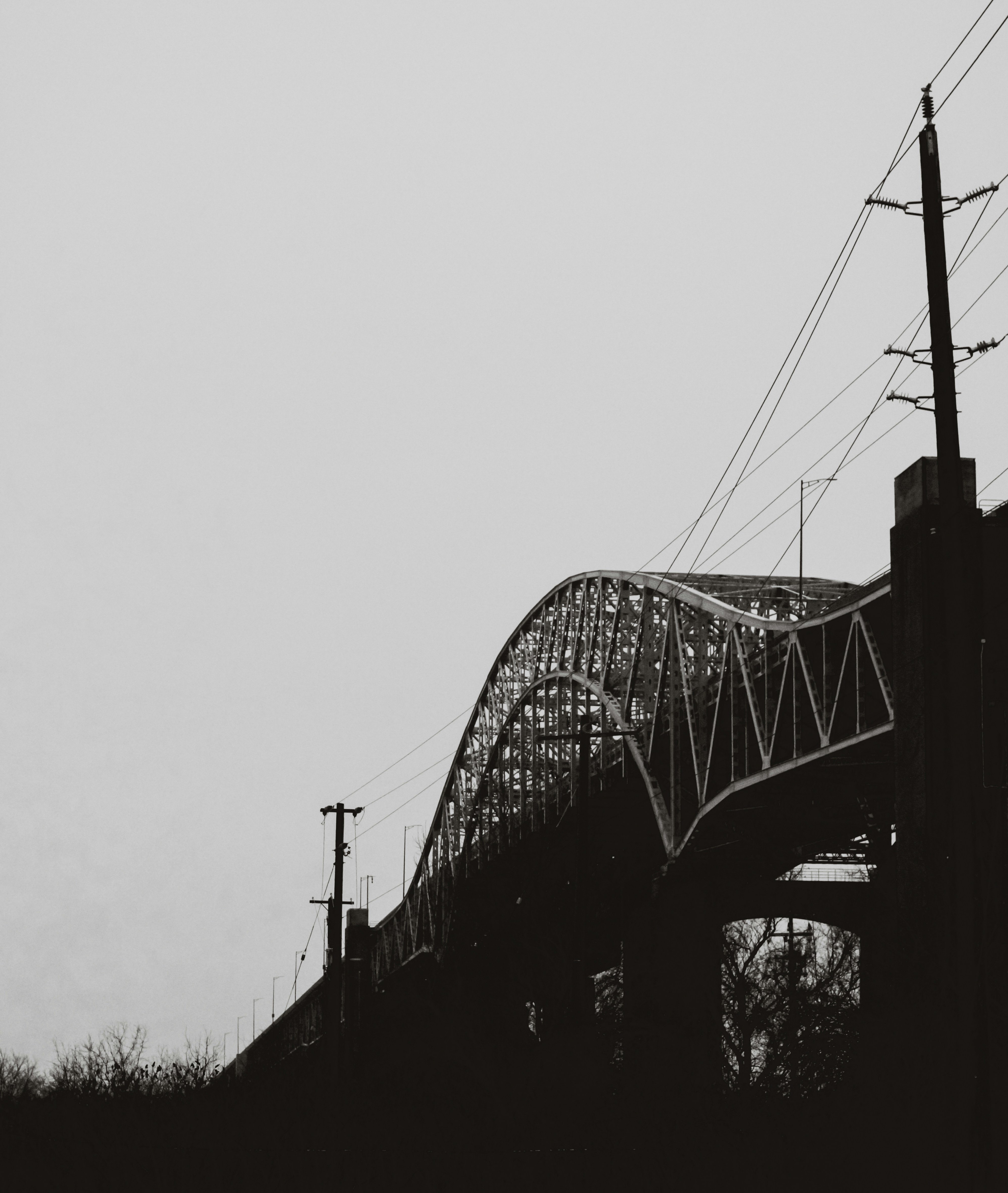 black and white shot under large bridge