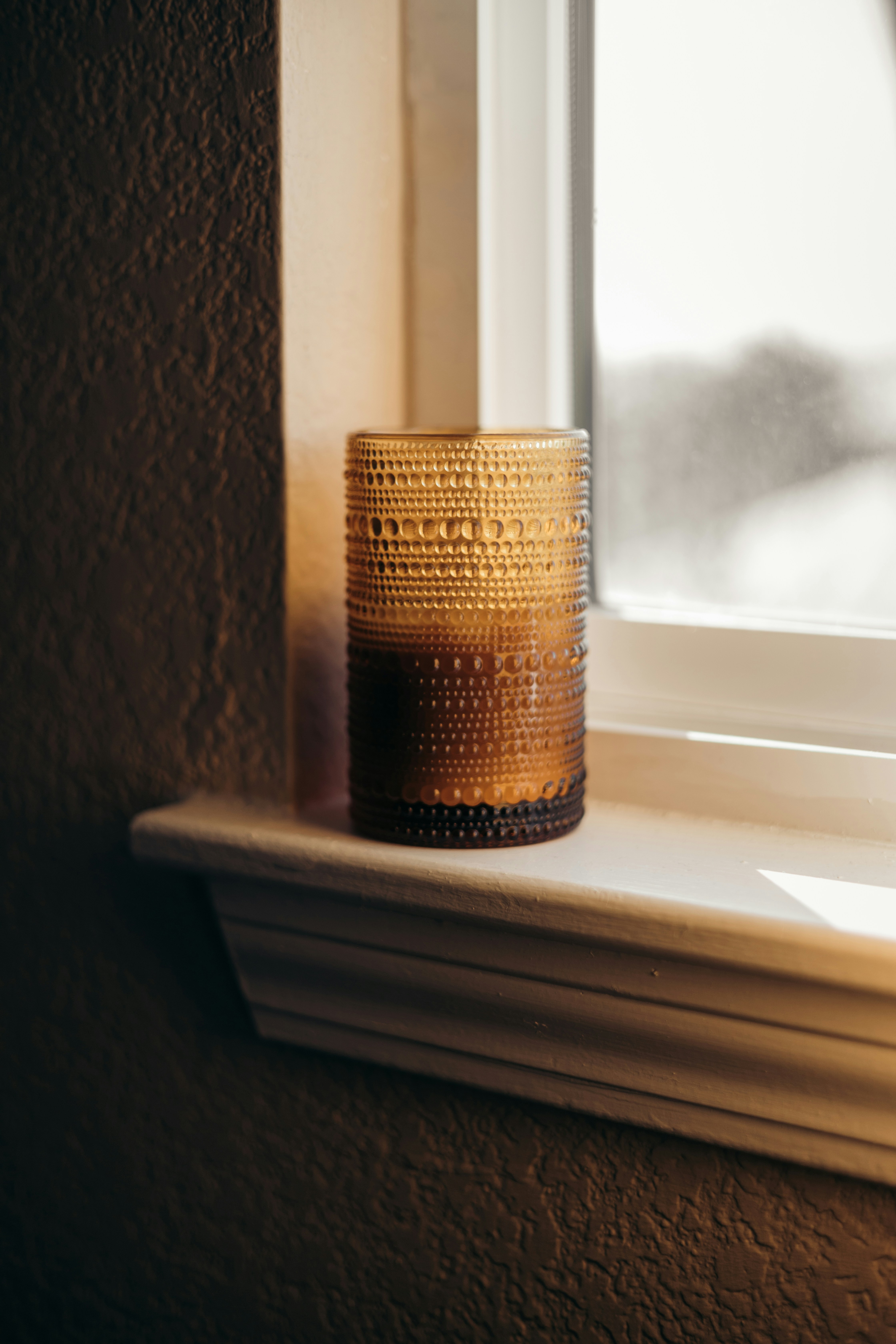 Glass Cylinder on Windowsill: Warm Glow by the Window