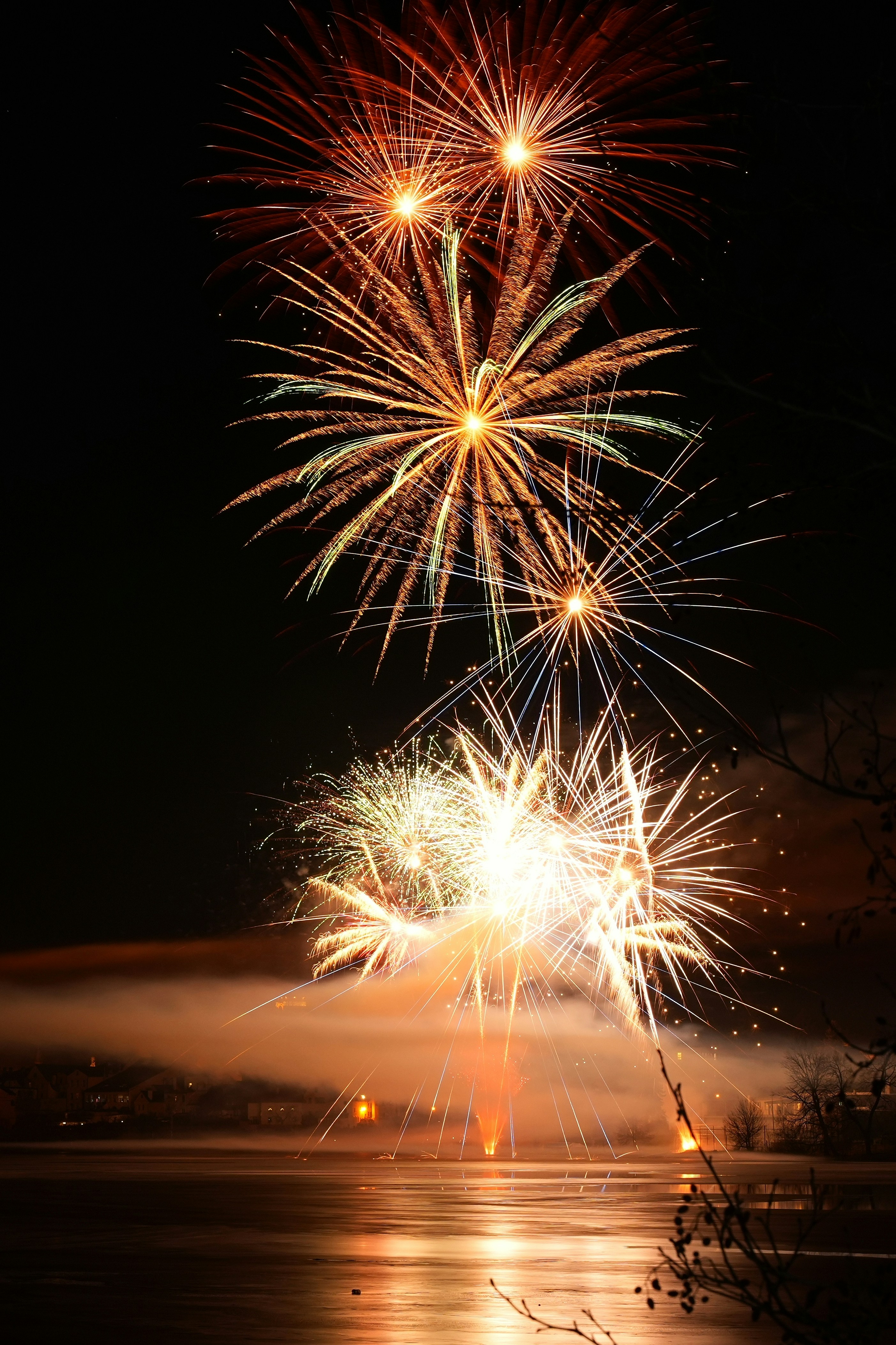 A firework display over a body of water at night photo – Free Fireworks ...
