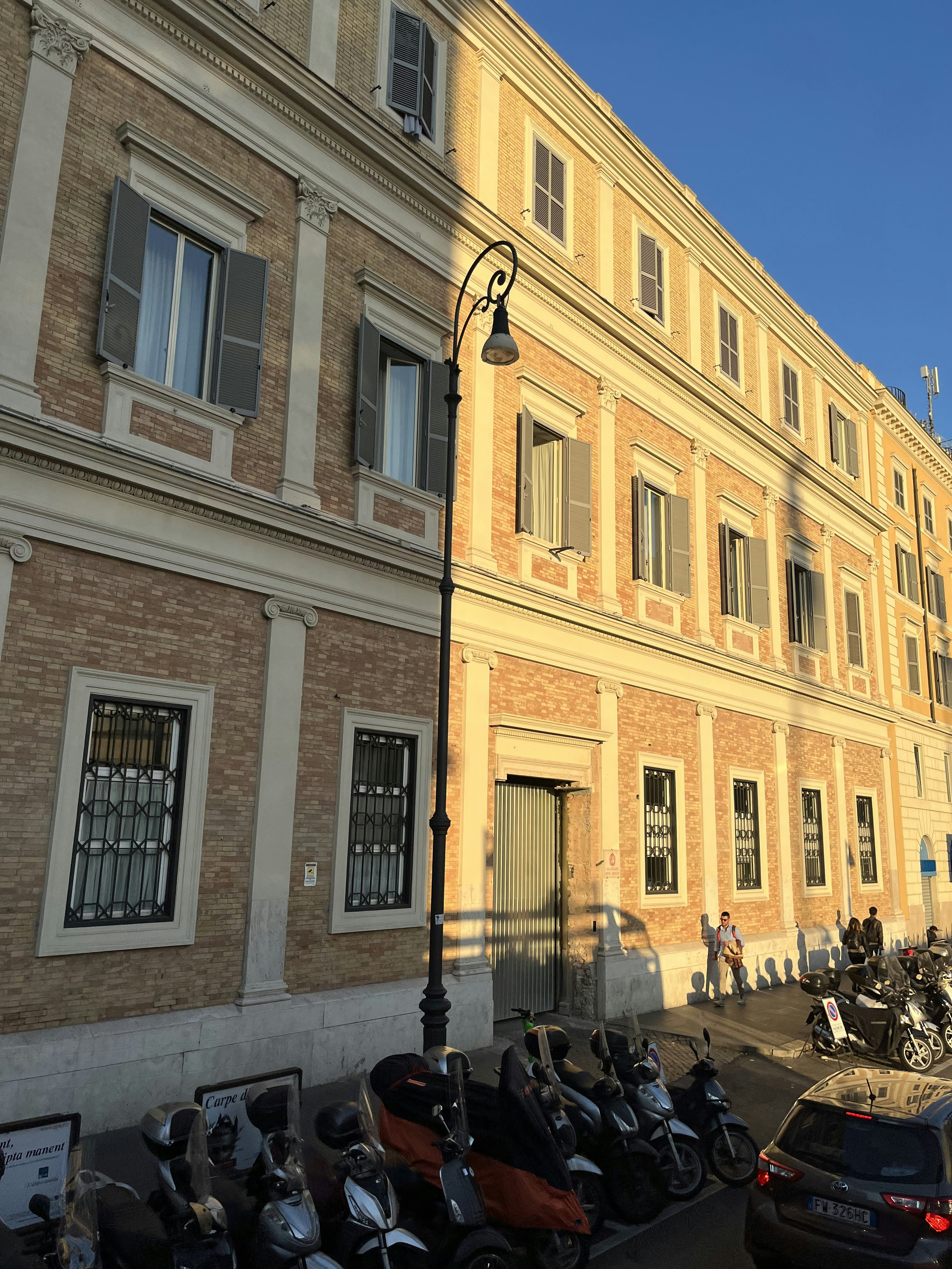 Amber Hour Illuminates a European Brick Facade and a Vintage Street Lamp