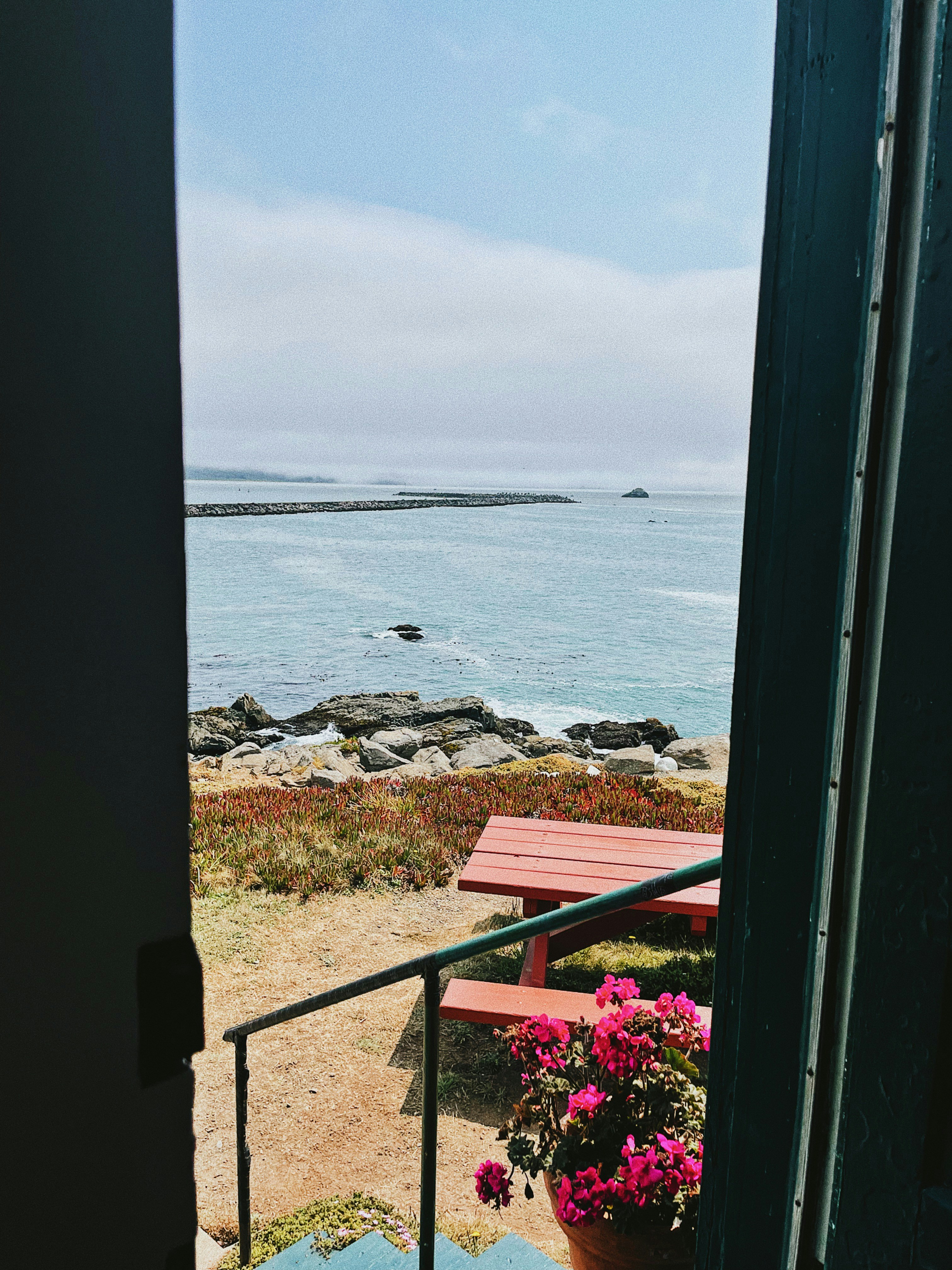 View Through a Seaside Doorway: Colorful Terrace by the Ocean