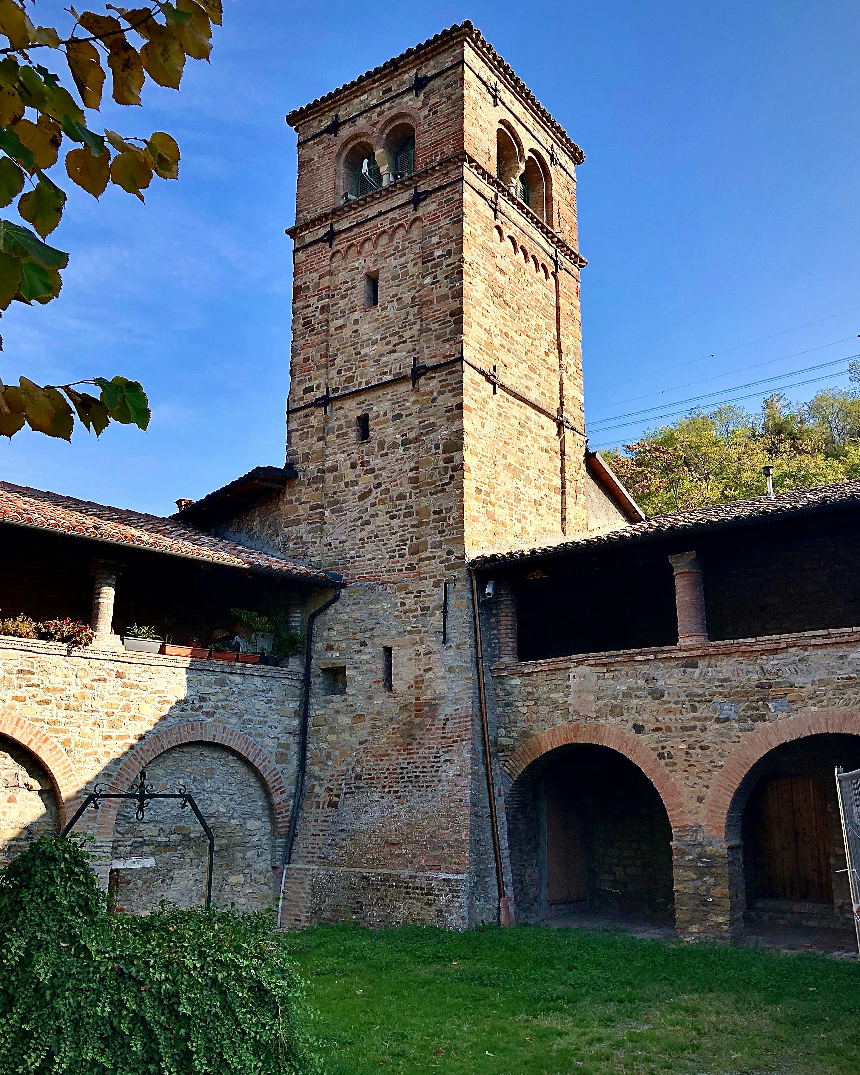 Historic stone tower and arches under a clear blue sky.
