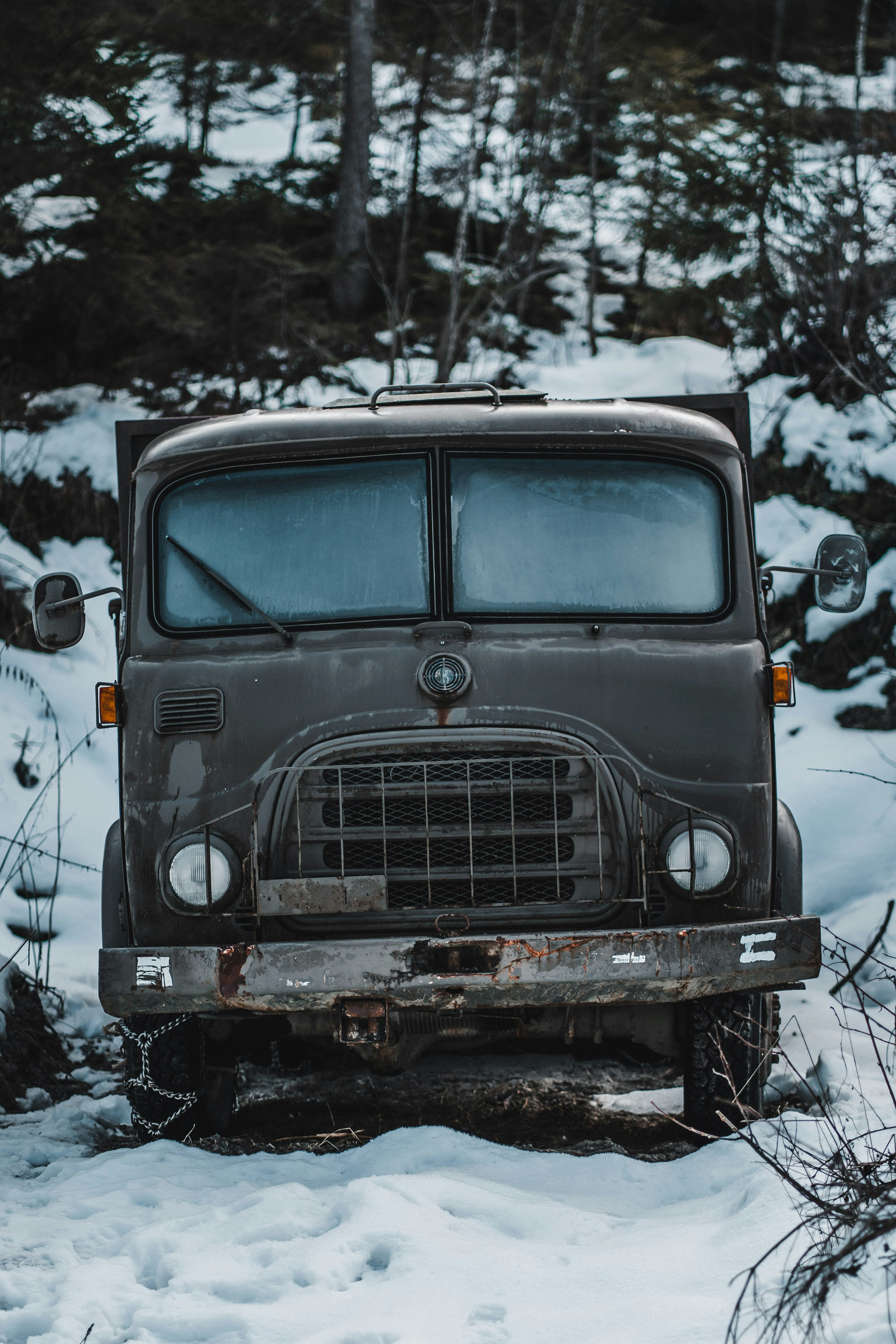 Snowbound Rust: The Front Grille of a Weathered Truck