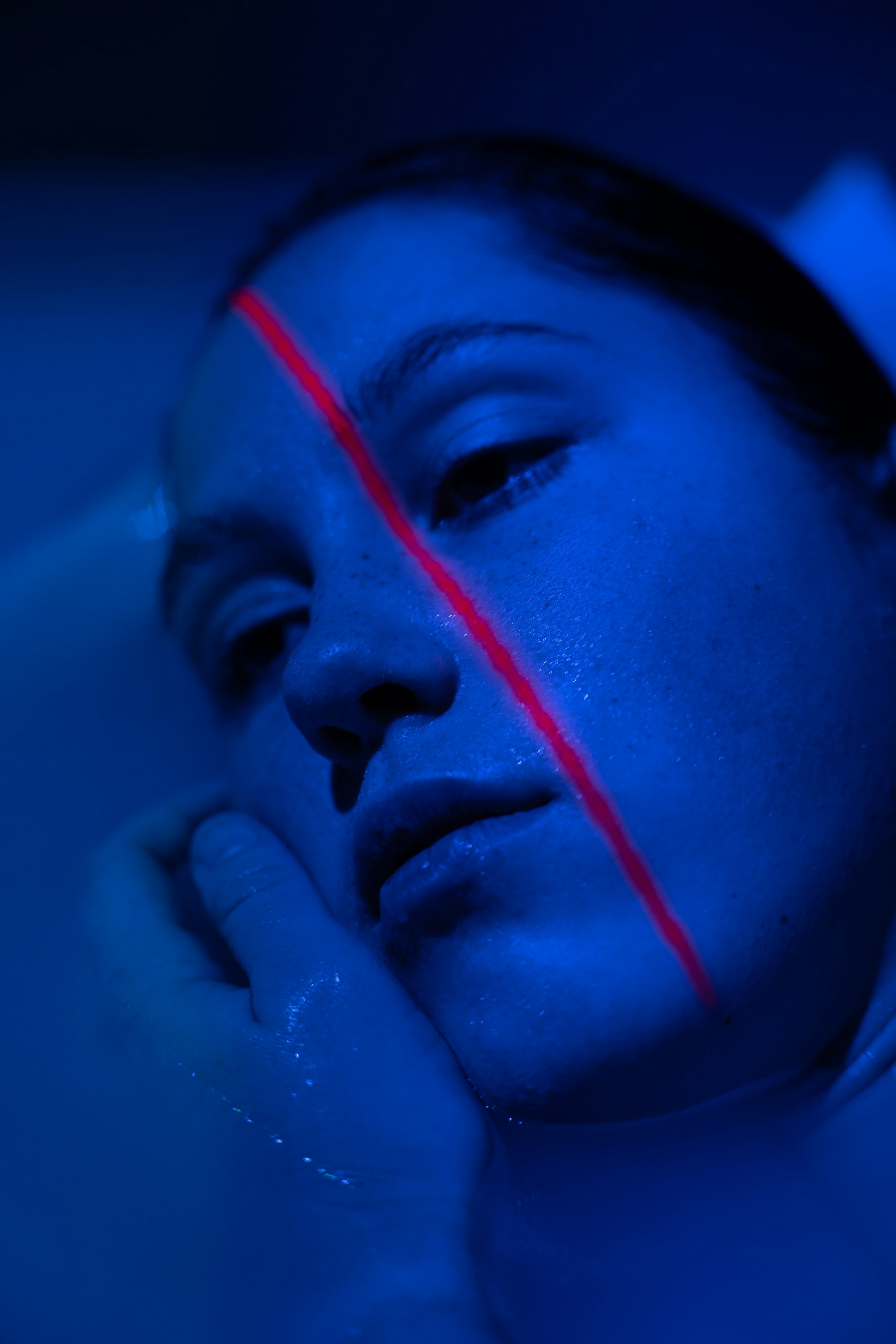A woman laying in a bathtub with a red line across her face photo ...