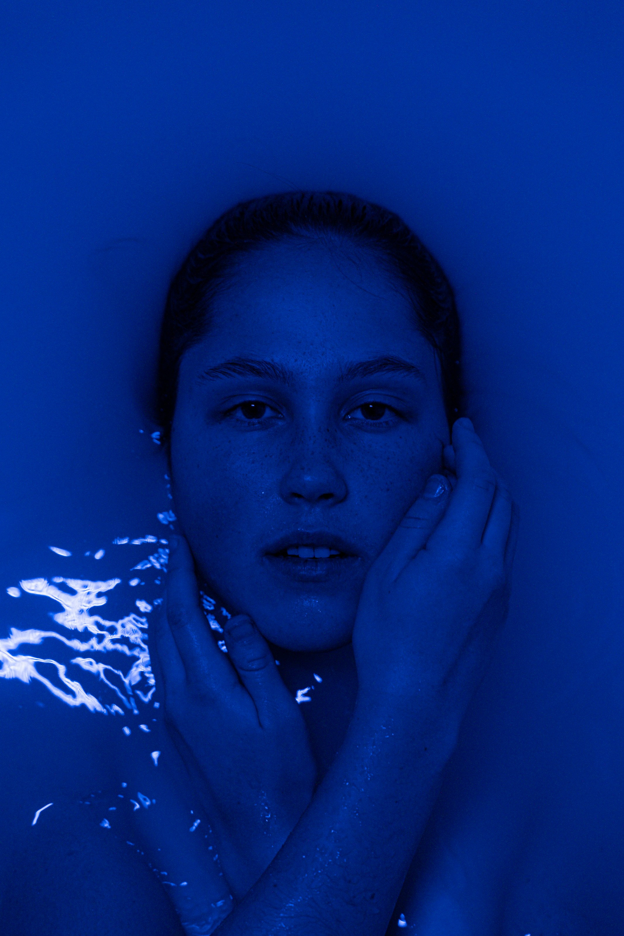 a woman in a bathtub with her hands on her face