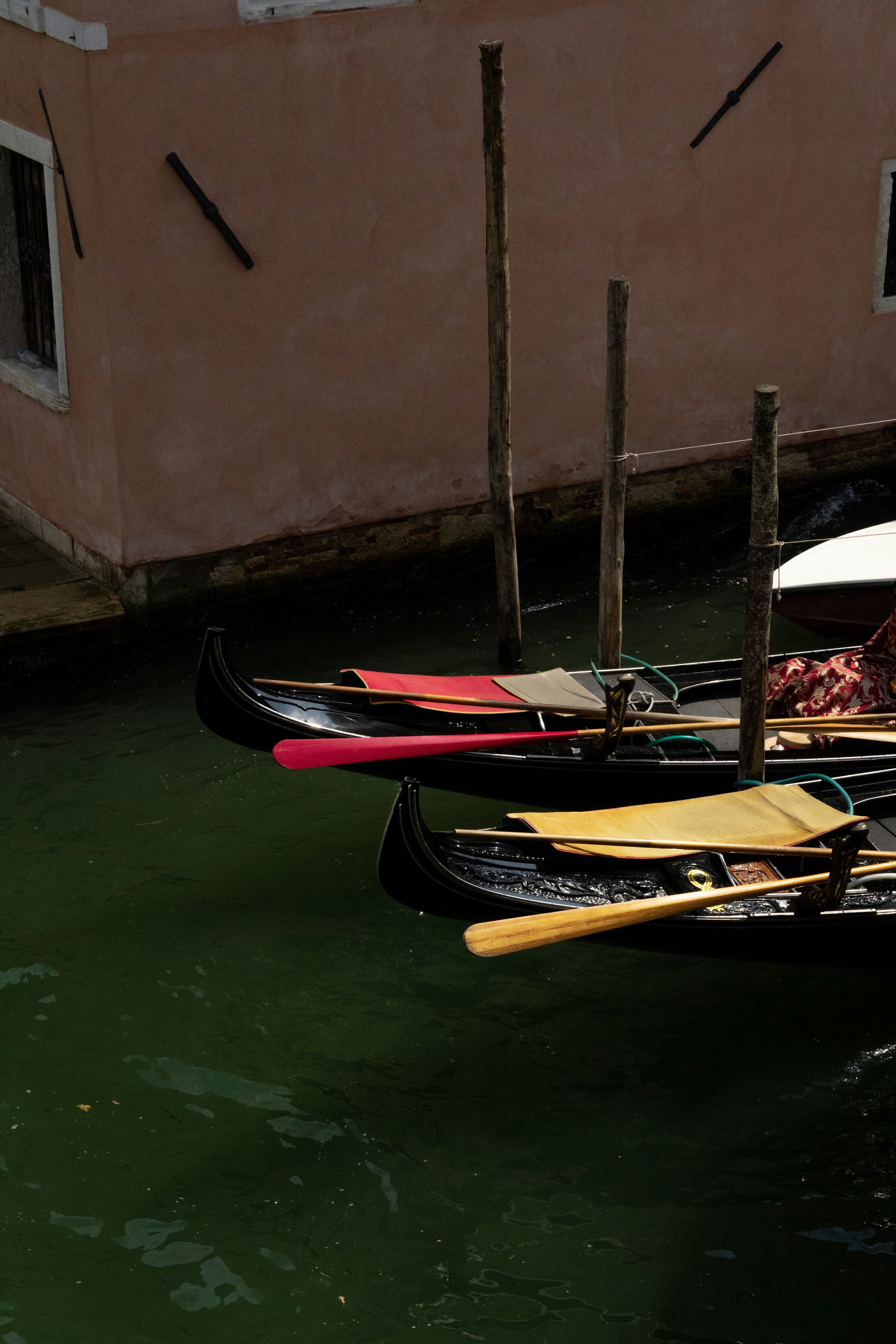 Gondola Palette: Oars Rest Across a Quiet Venice Canal
