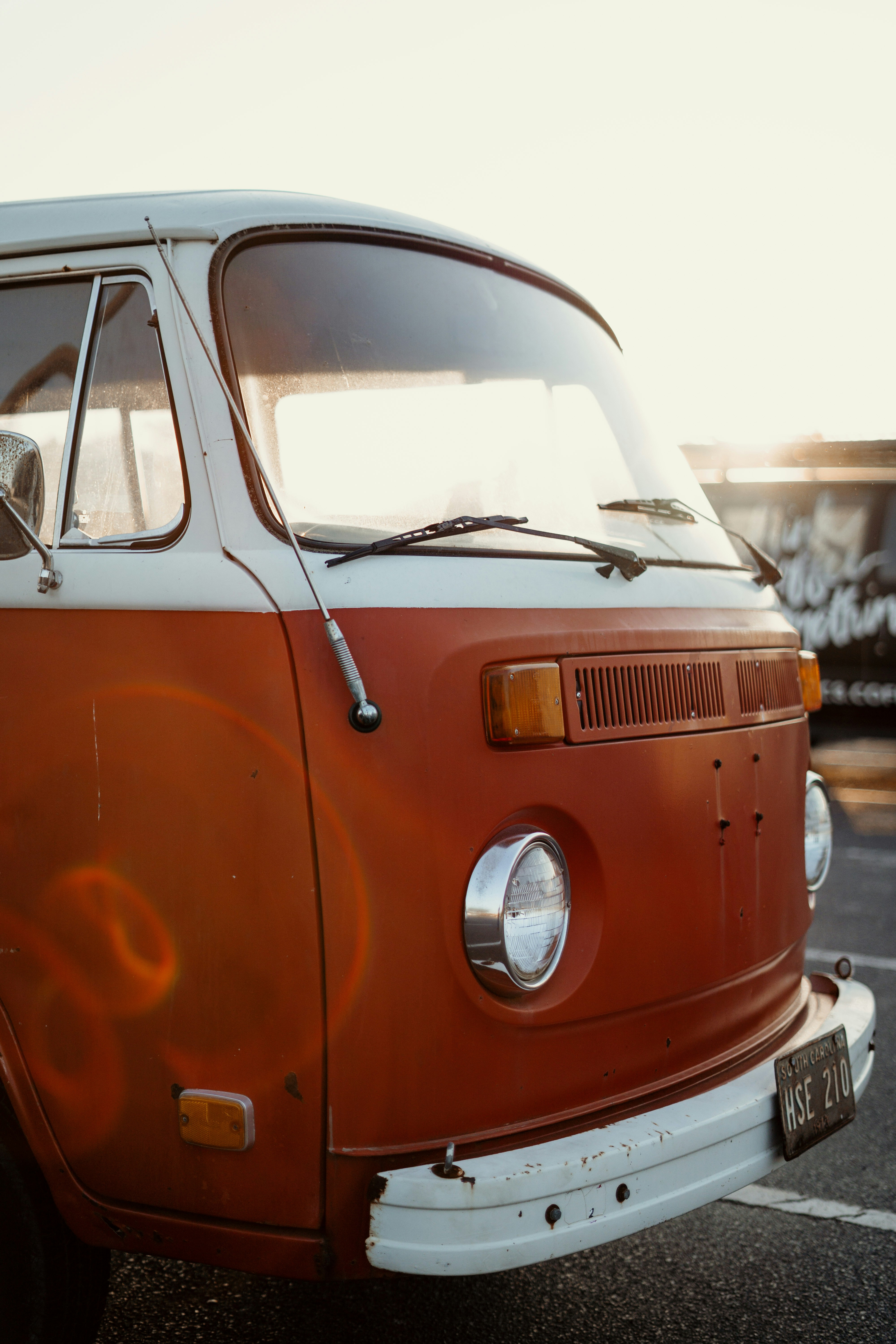 An orange and white van parked in a parking lot photo – Free Car Image ...