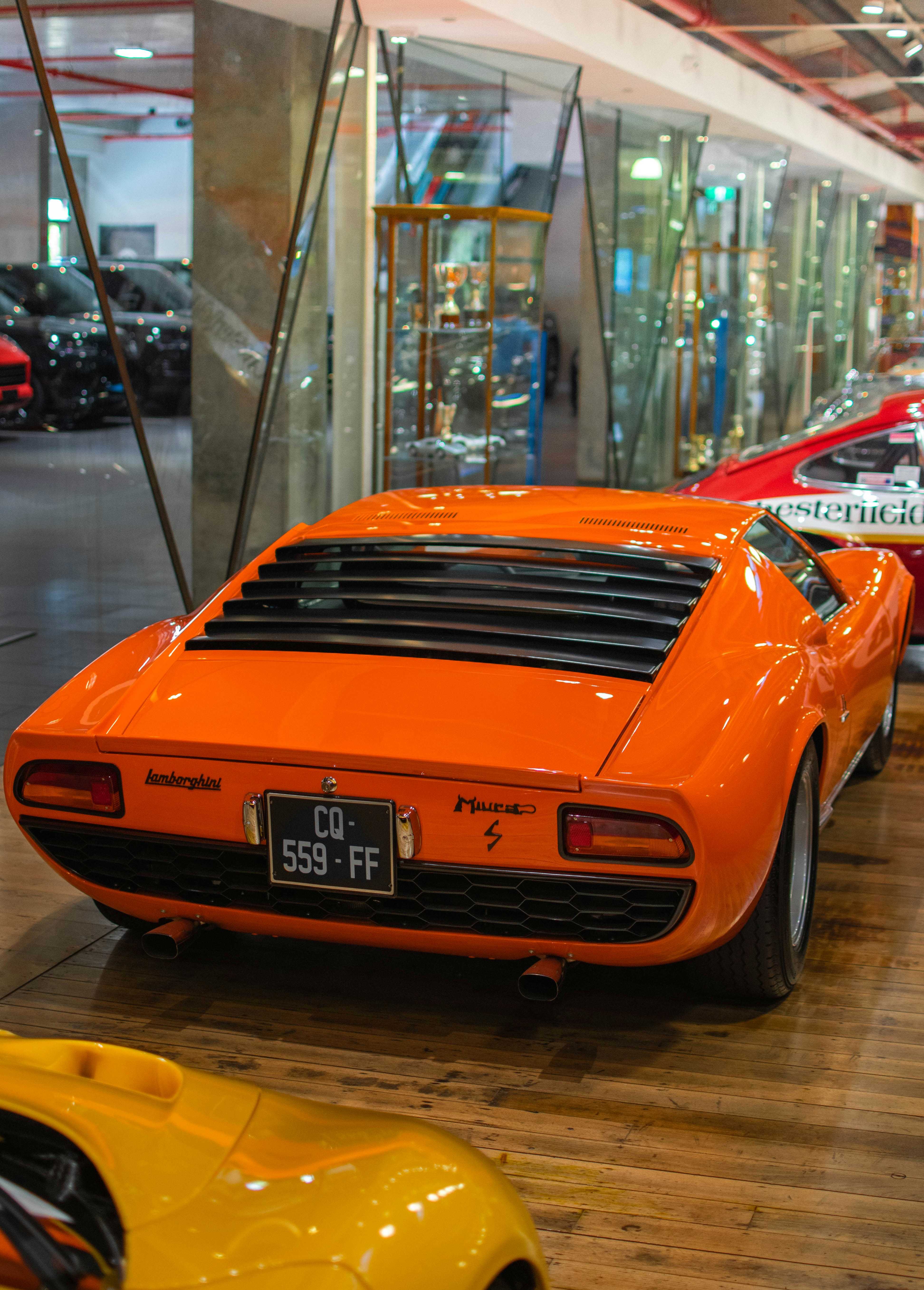A row of orange sports cars in a showroom photo – Free Australie Image ...