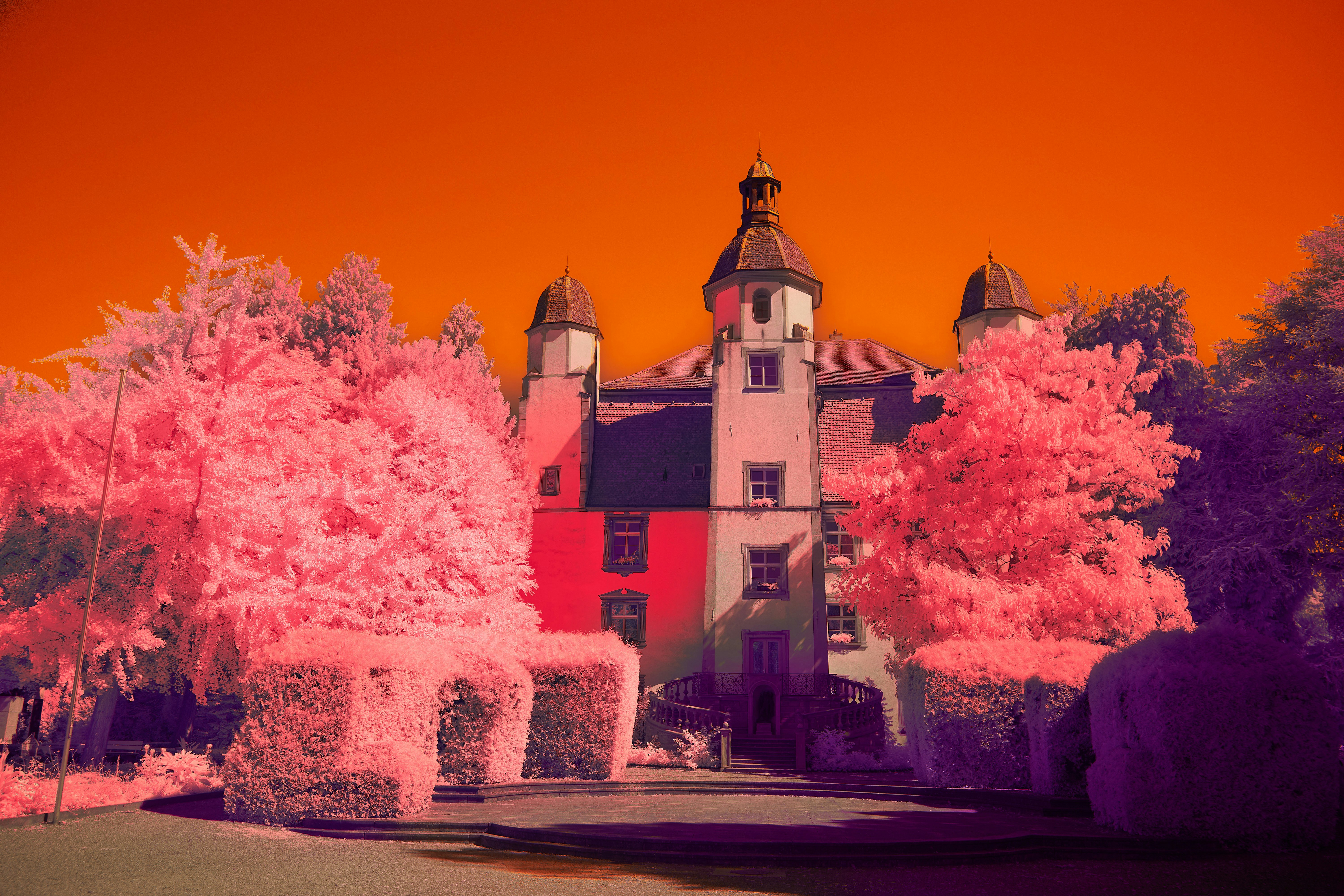 Infrared Dawn Over a Castle: Pink Trees Framing a Central Keep