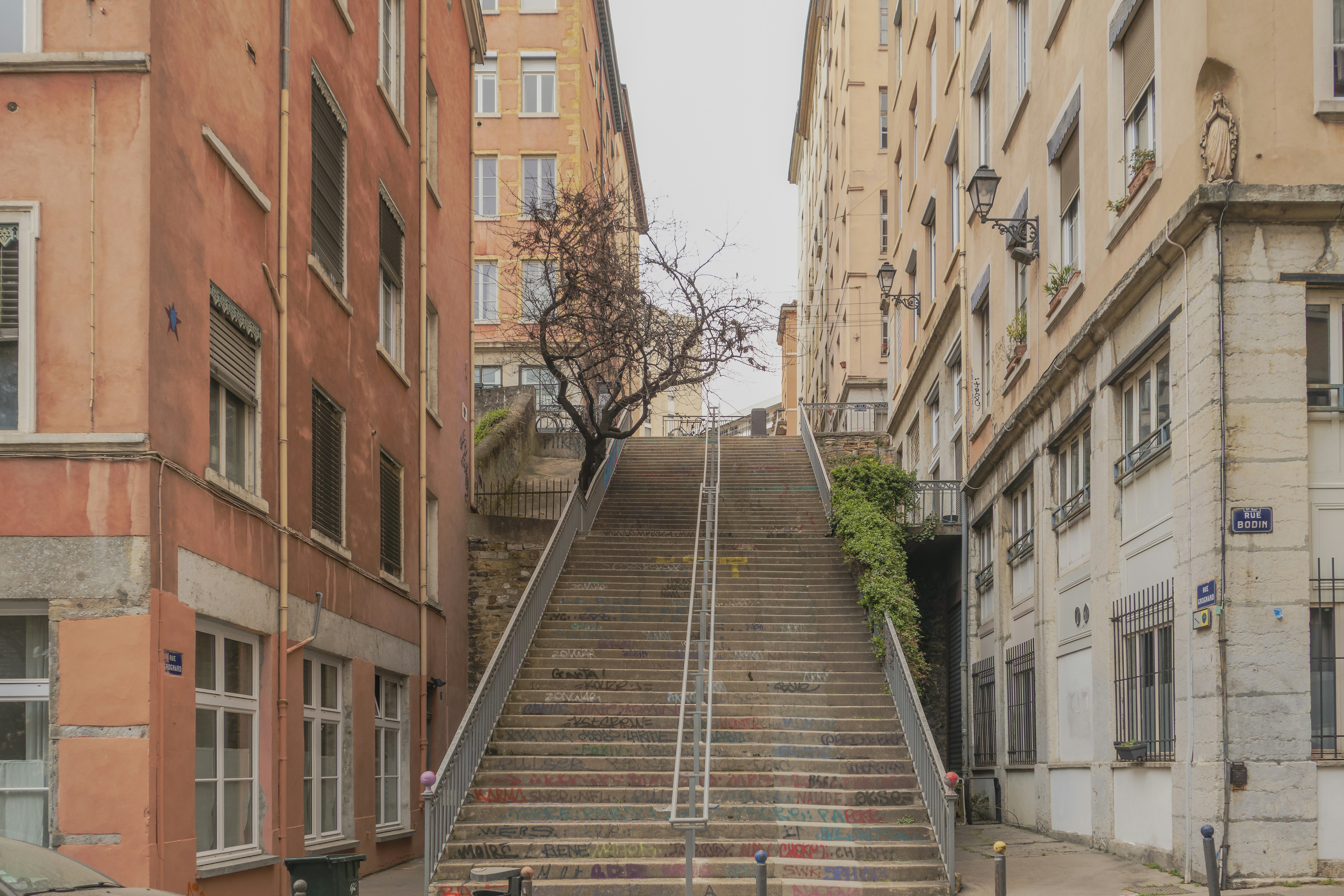 Les pentes et les escaliers dans le quartier de la Croix-Rousse à Lyon. Lyon, grande ville carrefour de l'Europe, mystérieuse et lumineuse, elle égaie le touriste par sa richesse culturelle et artistique et de par son histoire deux fois millénaire. Et comme dit la mère Cottivet, « En descendant montez donc, vous verrez le petit comme il est grand ».