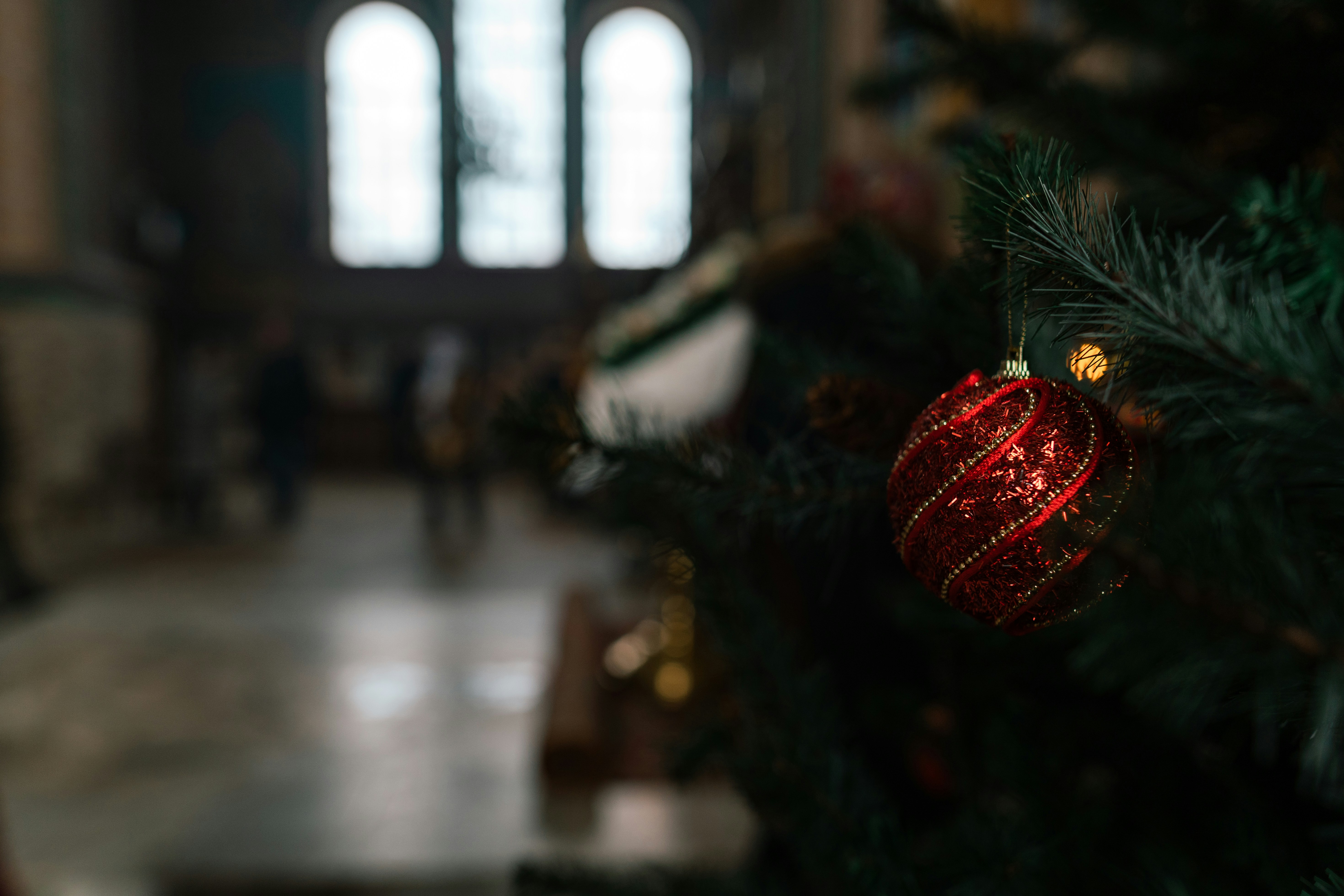 a red ornament hanging from a christmas tree