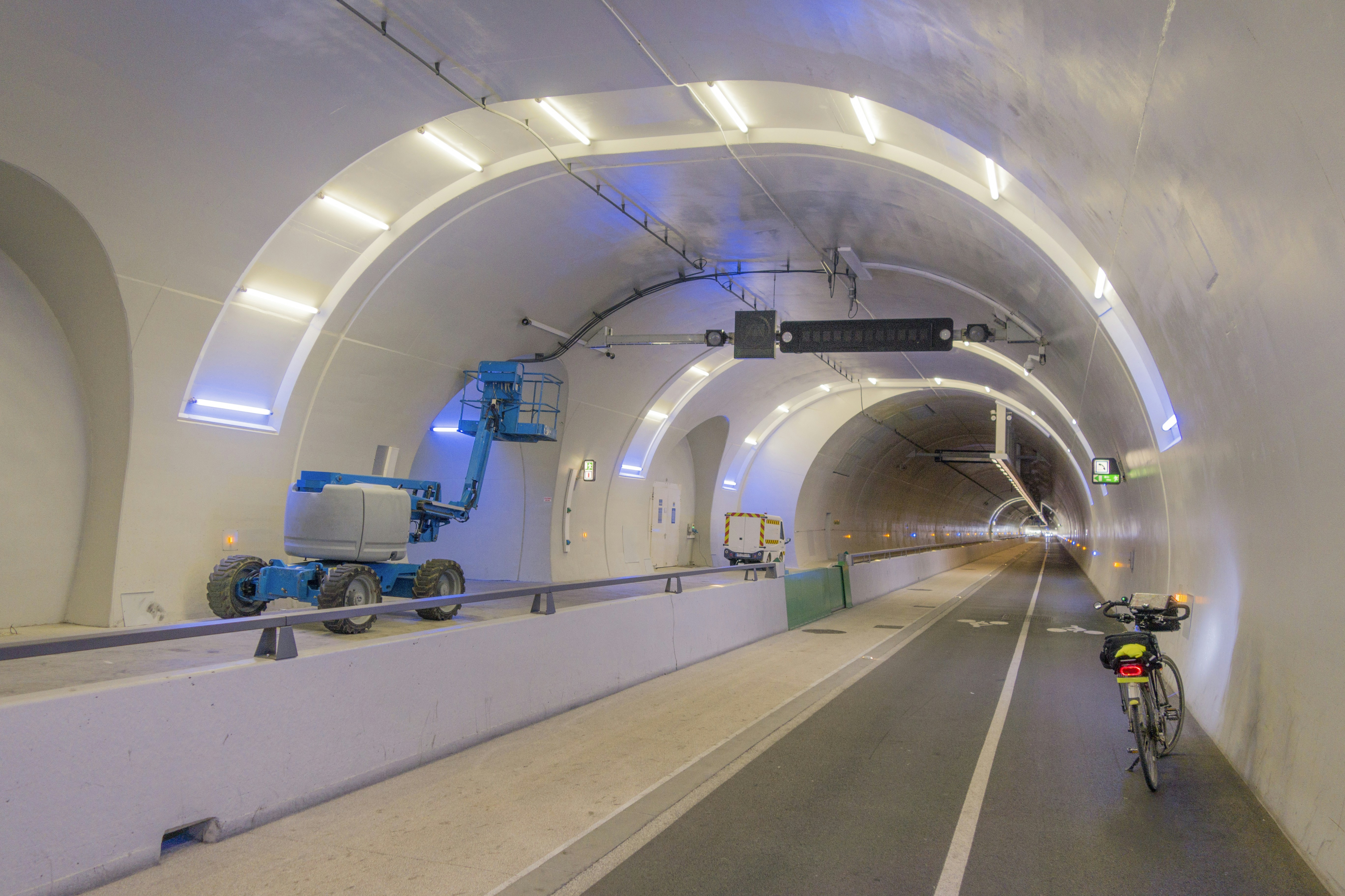 a man riding a bike down a tunnel