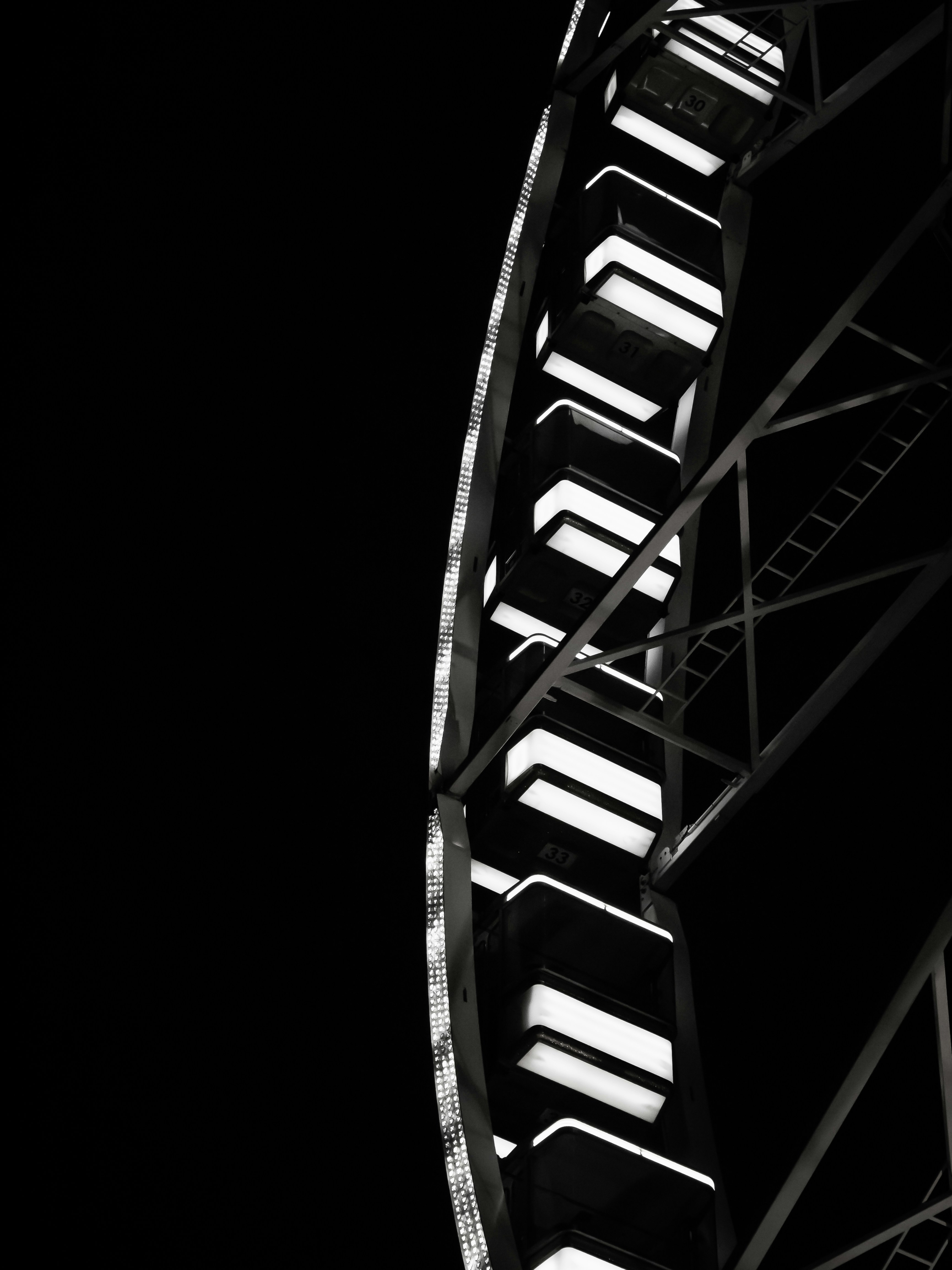 Neon Cabins Ascend on a Monochrome Ferris Wheel