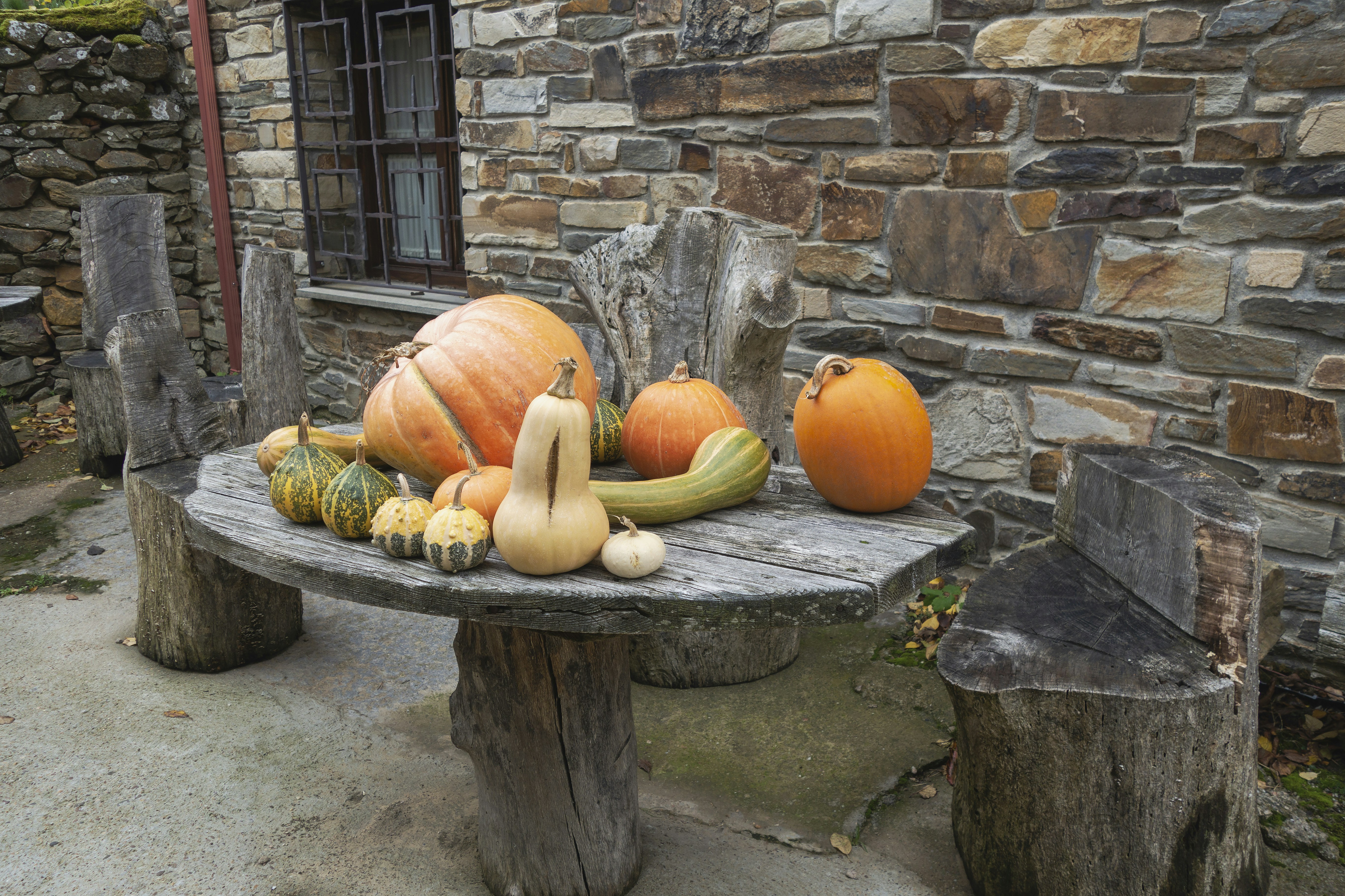 a wooden table topped with pumpkins and gourds