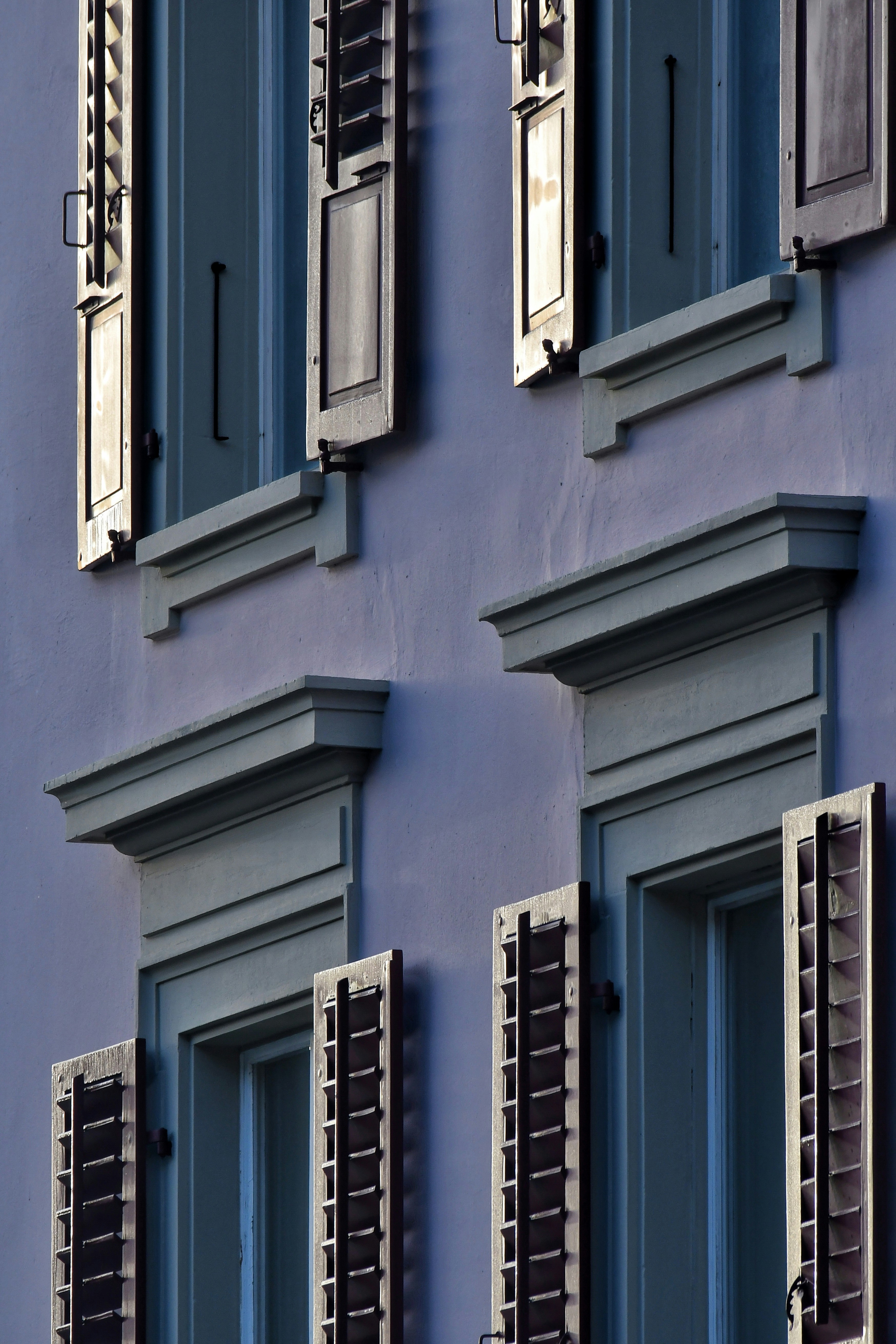 Un bâtiment bleu avec plusieurs fenêtres et volets photo – Photo Suisse ...