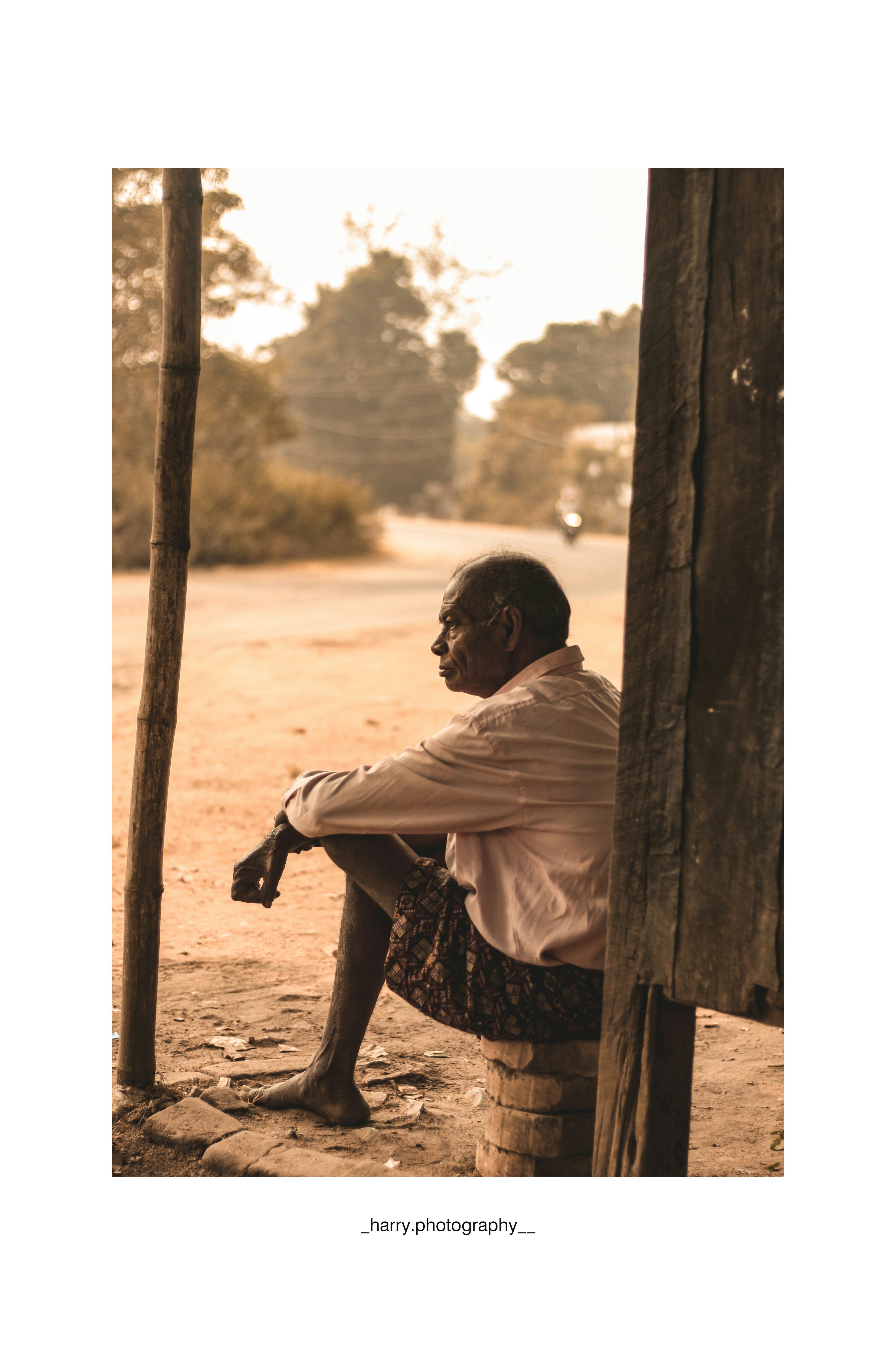 A man sitting on a wooden post in the dirt photo – Free Portrait Image ...