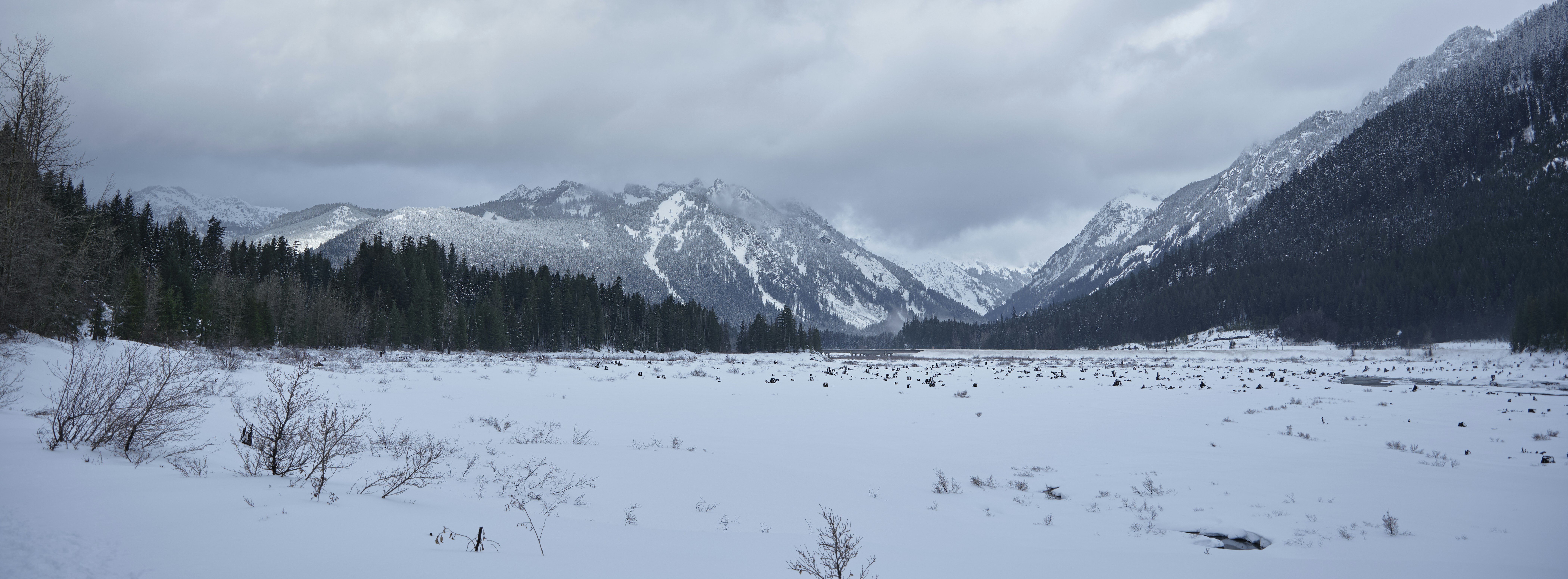 Snow-Locked Valley Under Cloud-Washed Peaks
