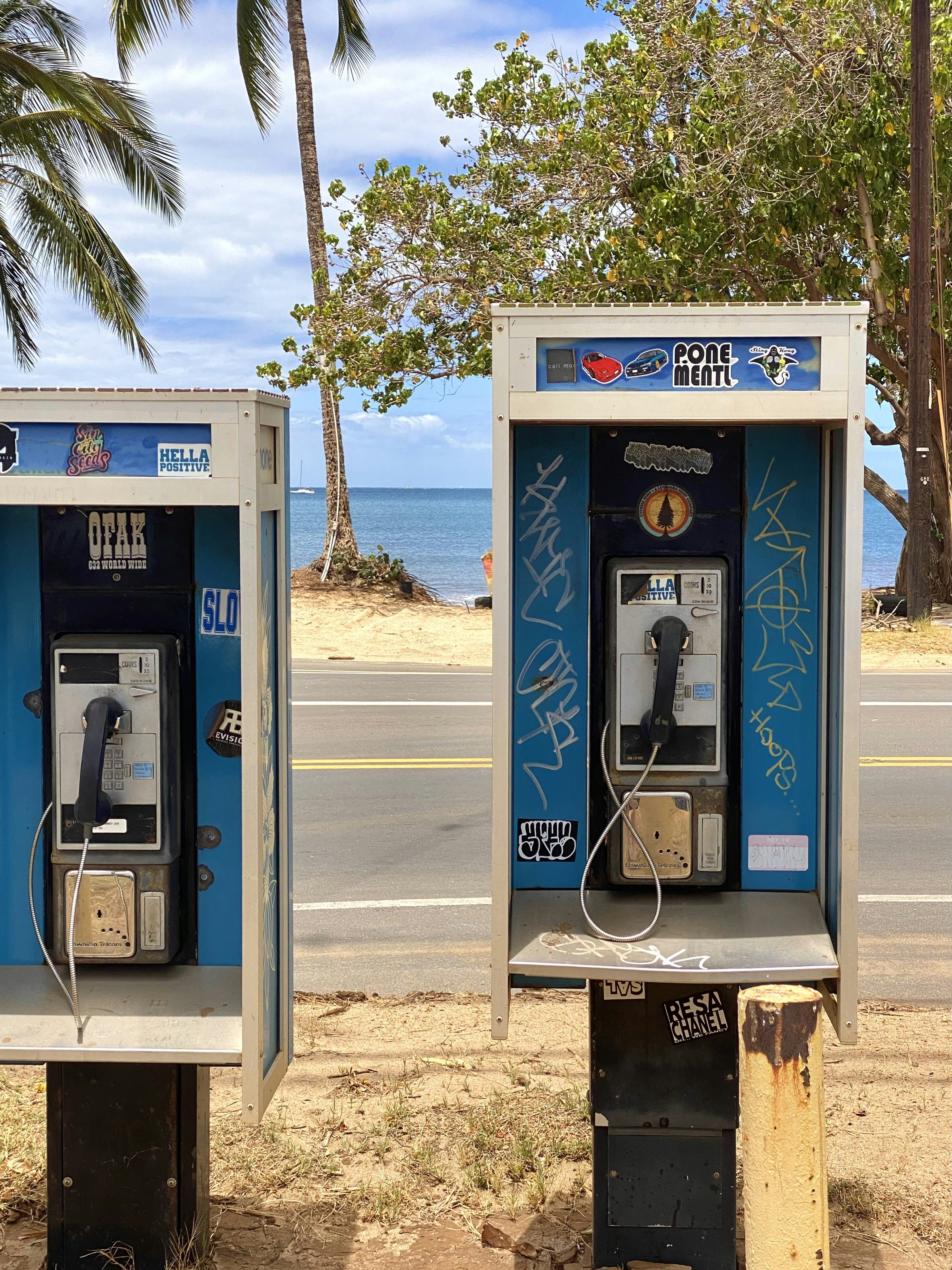 Two old style pay phones sitting on the side of the road photo – Free ...