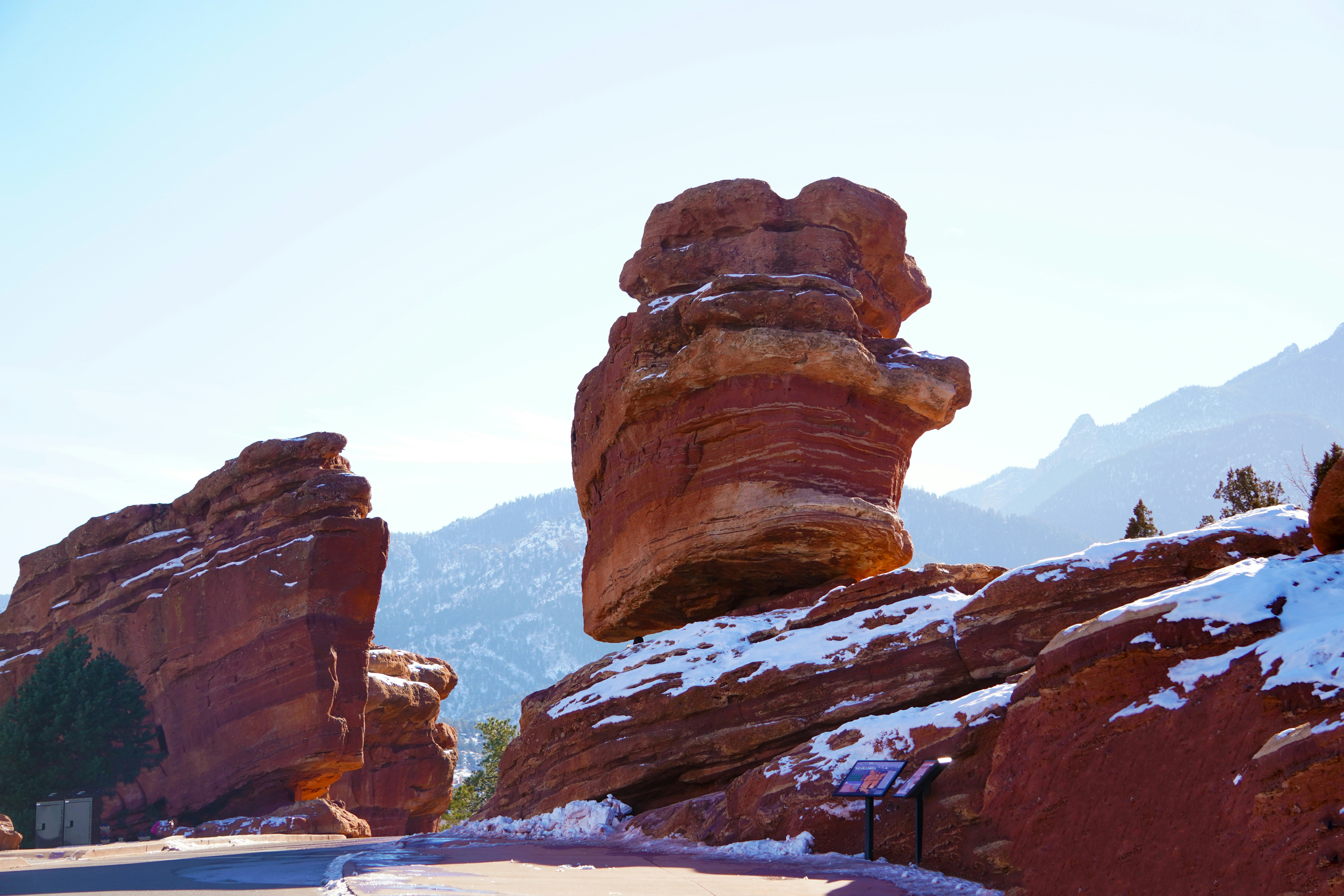 Balanced Sentinel: Snow-Covered Red Rock Tower Against a Blue Sky
