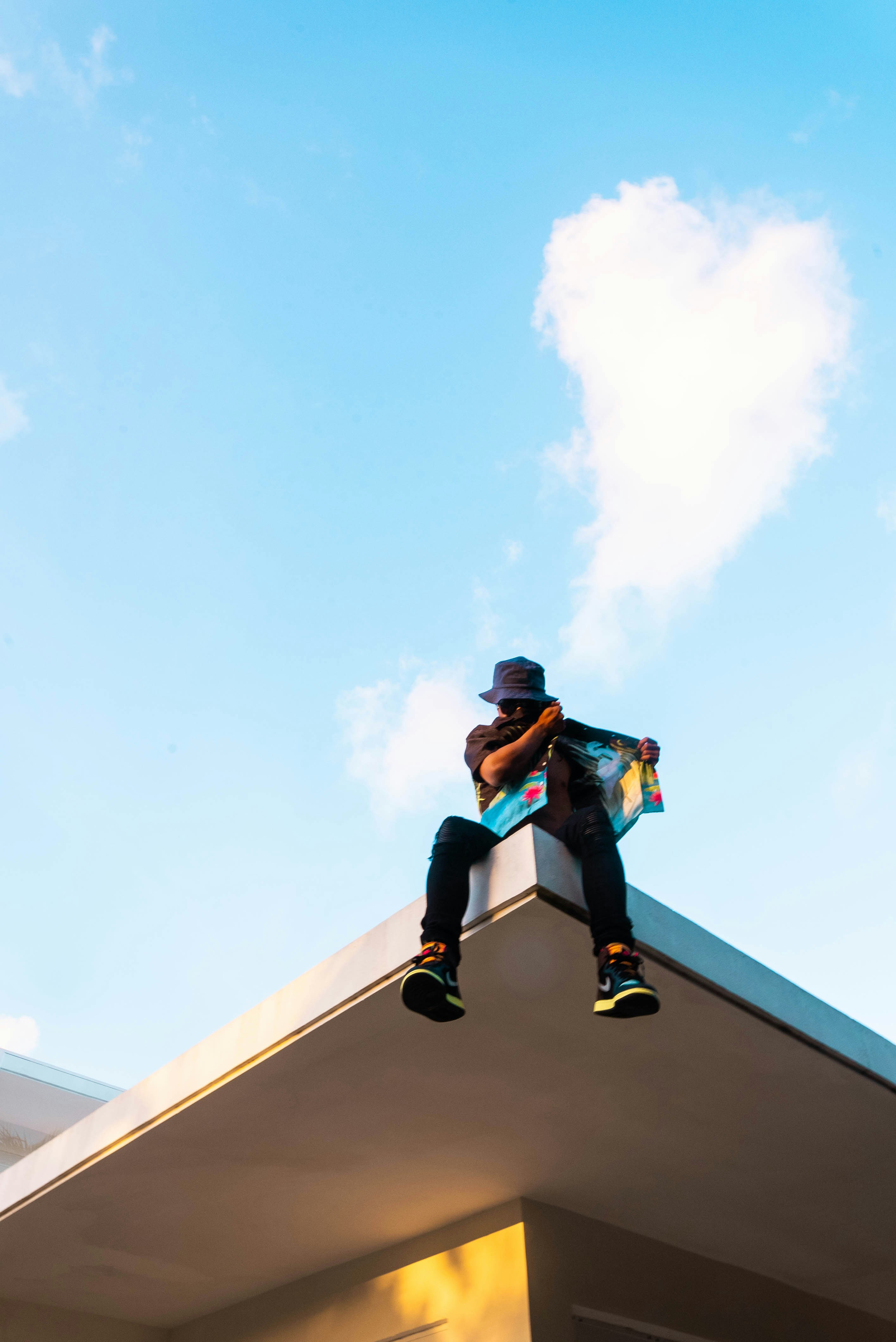 Edge of the Sky: Rooftop Skateboarder Pauses with a Painted Board