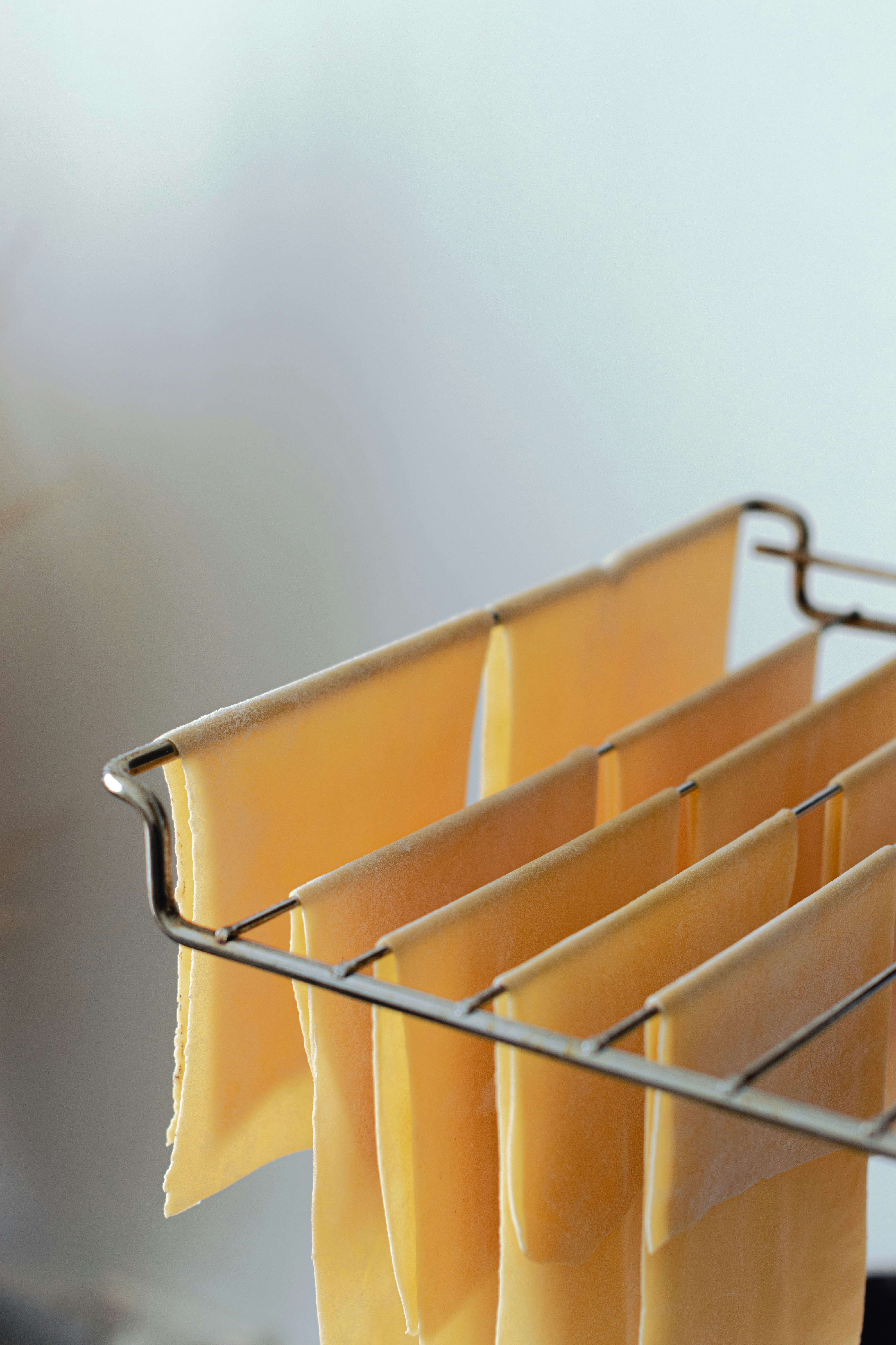 A bunch of cheese is hanging on a rack photo – Free Drying rack Image ...