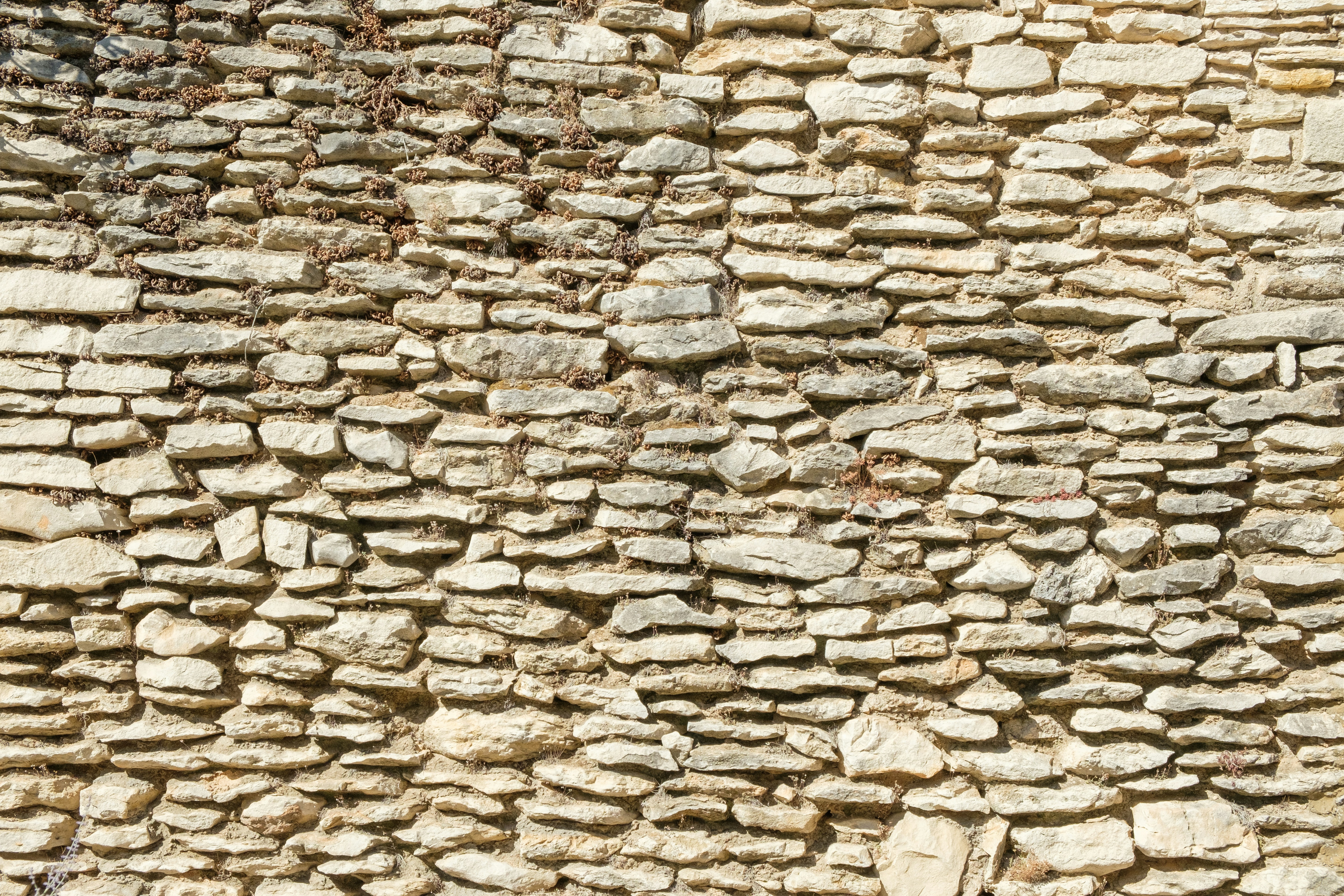 Foto Un muro de piedra hecho de pequeñas rocas – Imagen Pared gratis en ...