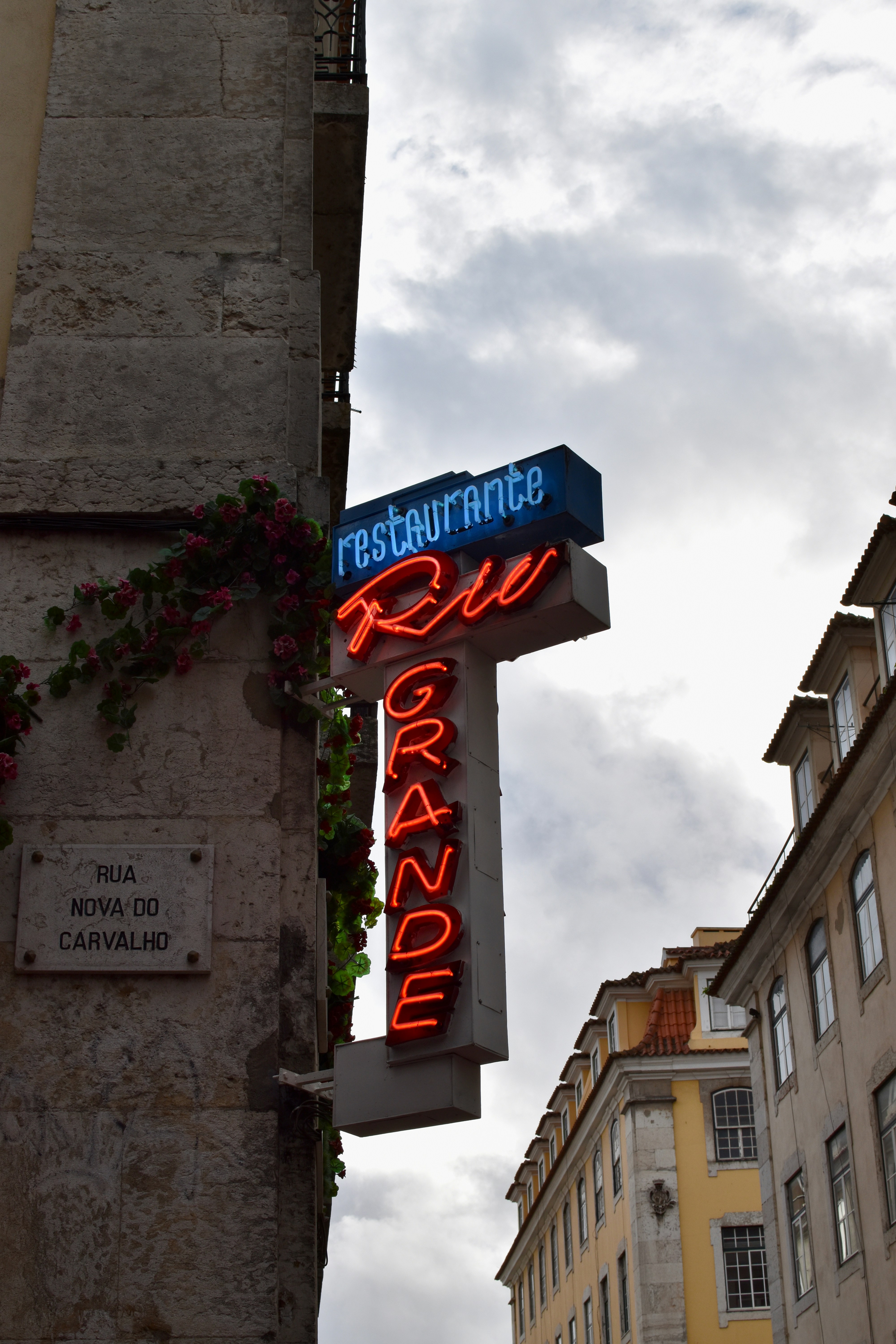 A neon sign hanging from the side of a building photo – Free Image on ...