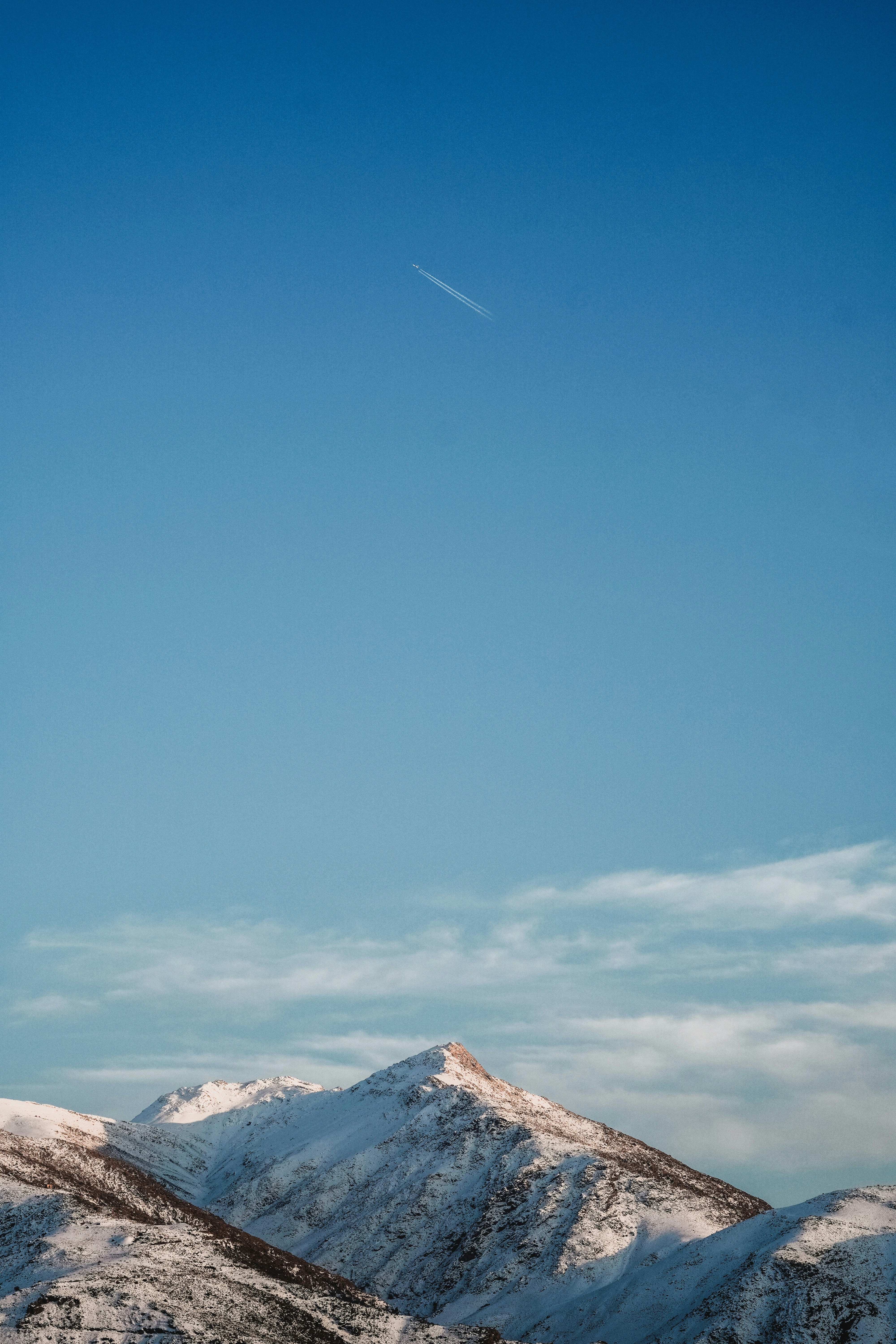 A plane flying over a snow covered mountain range photo – Free Scenery ...