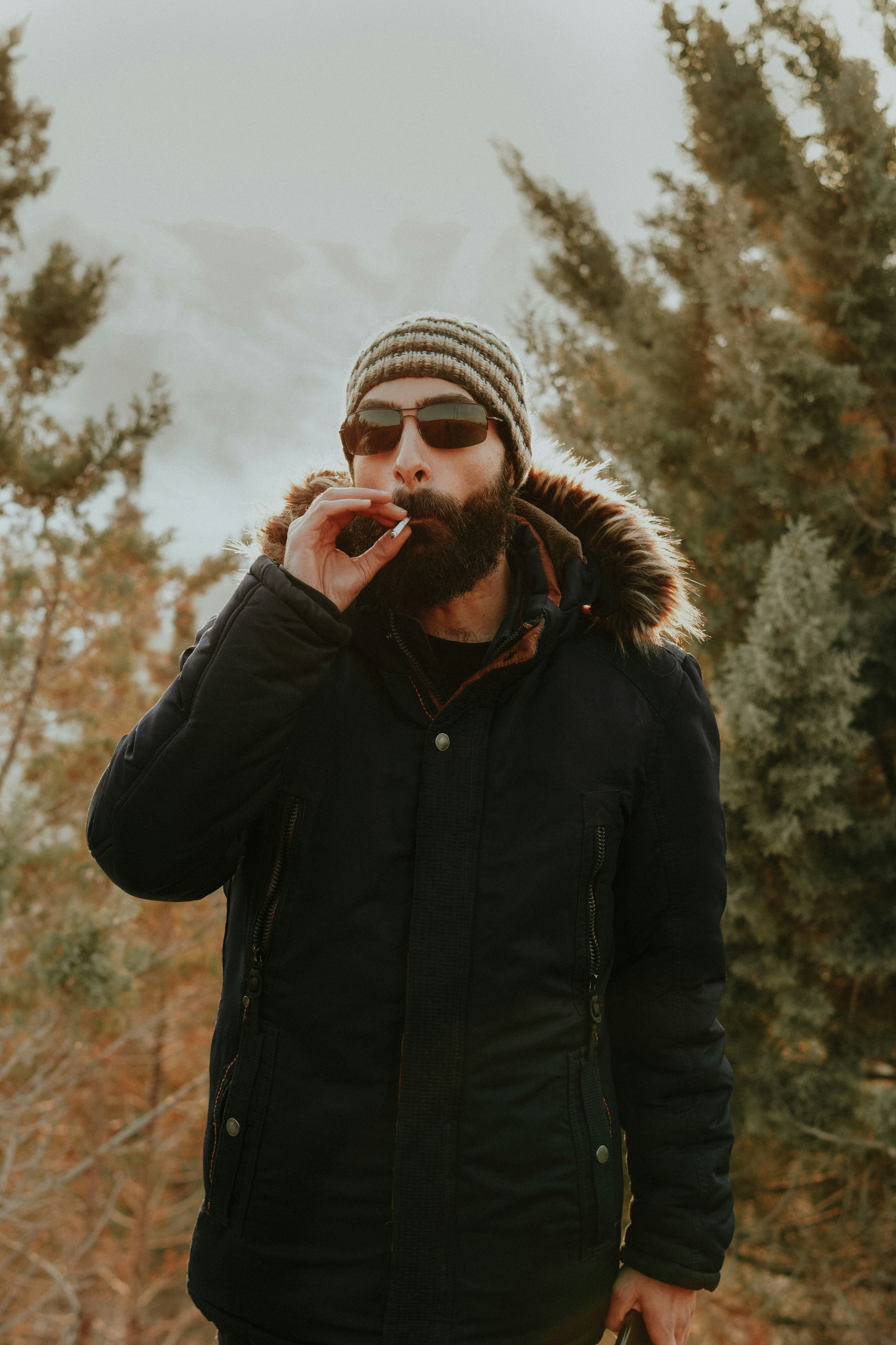 a man with a beard is smoking a cigarette