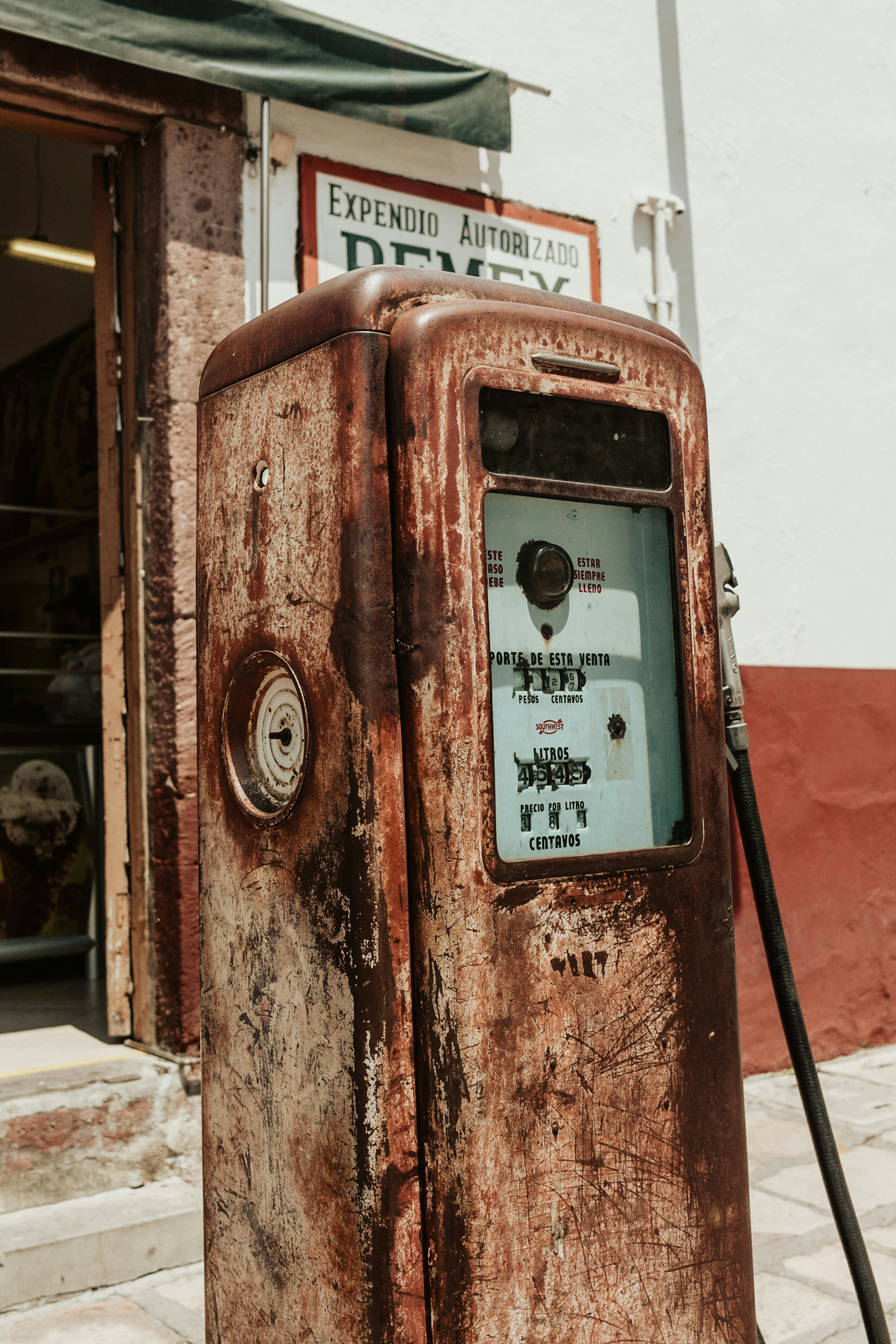 An old rusty gas pump on the side of the road photo – Free Vintage ...
