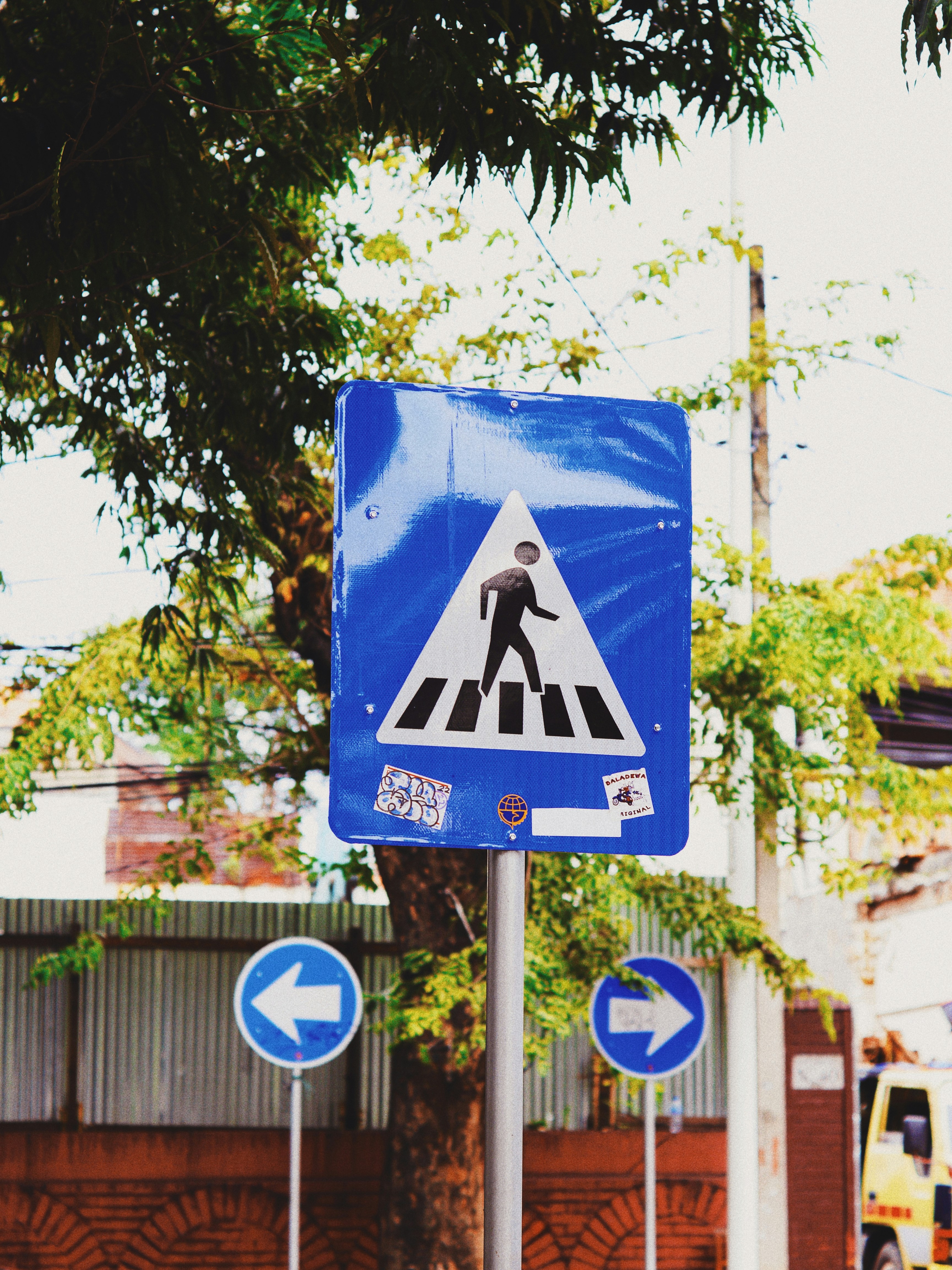 A blue pedestrian crossing sign sitting on the side of a road photo ...