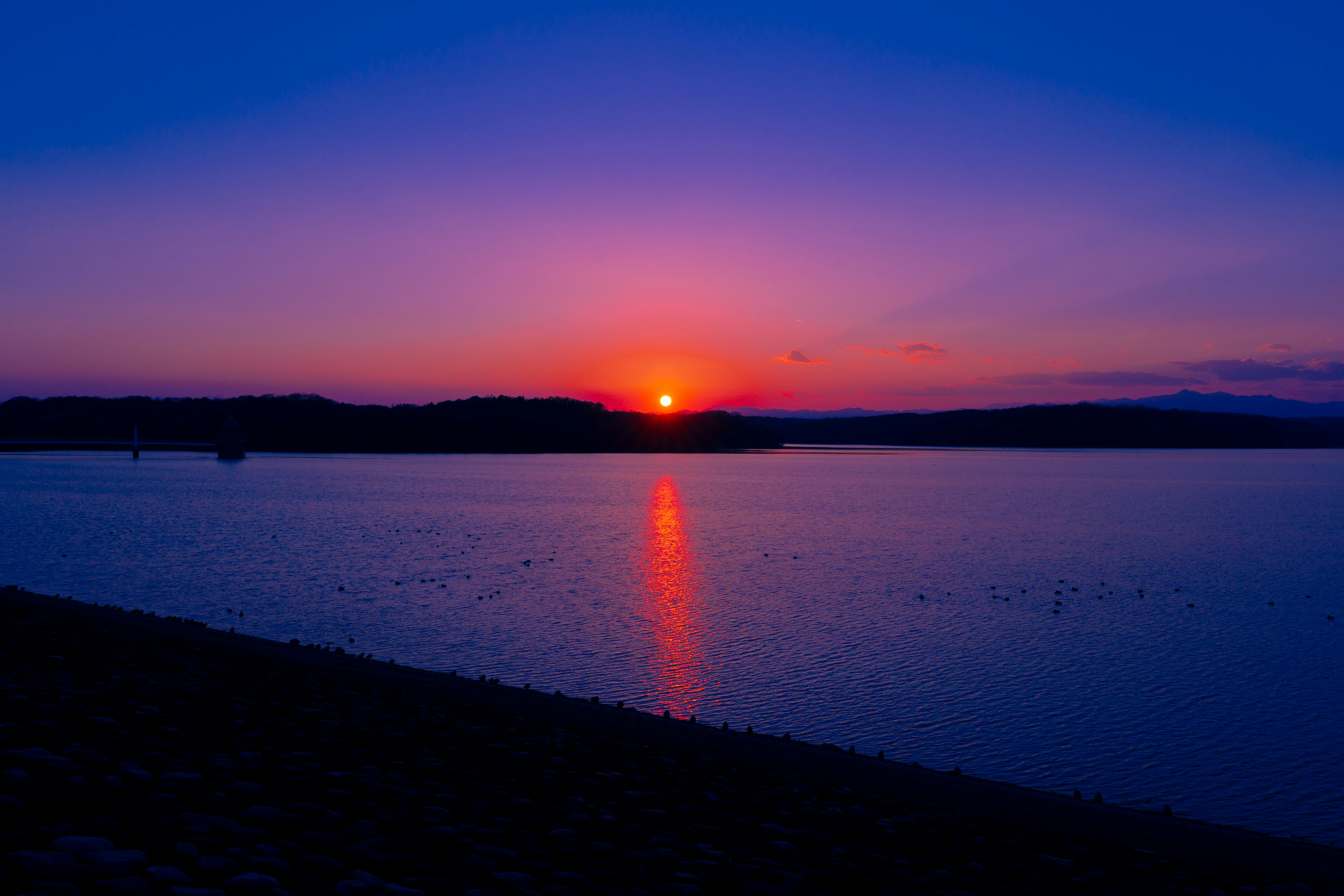 the sun is setting over a body of water