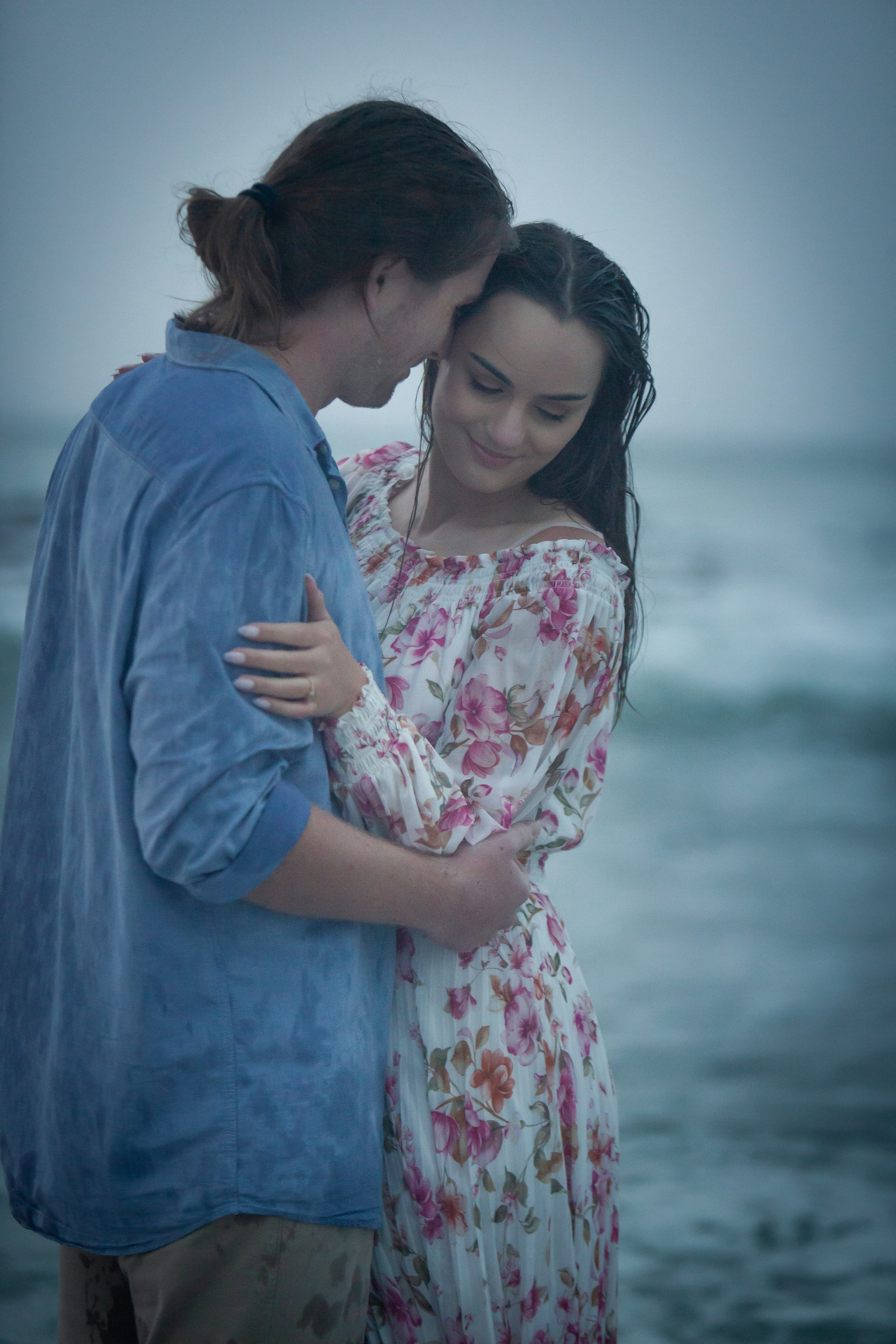 a man and a woman embracing on the beach