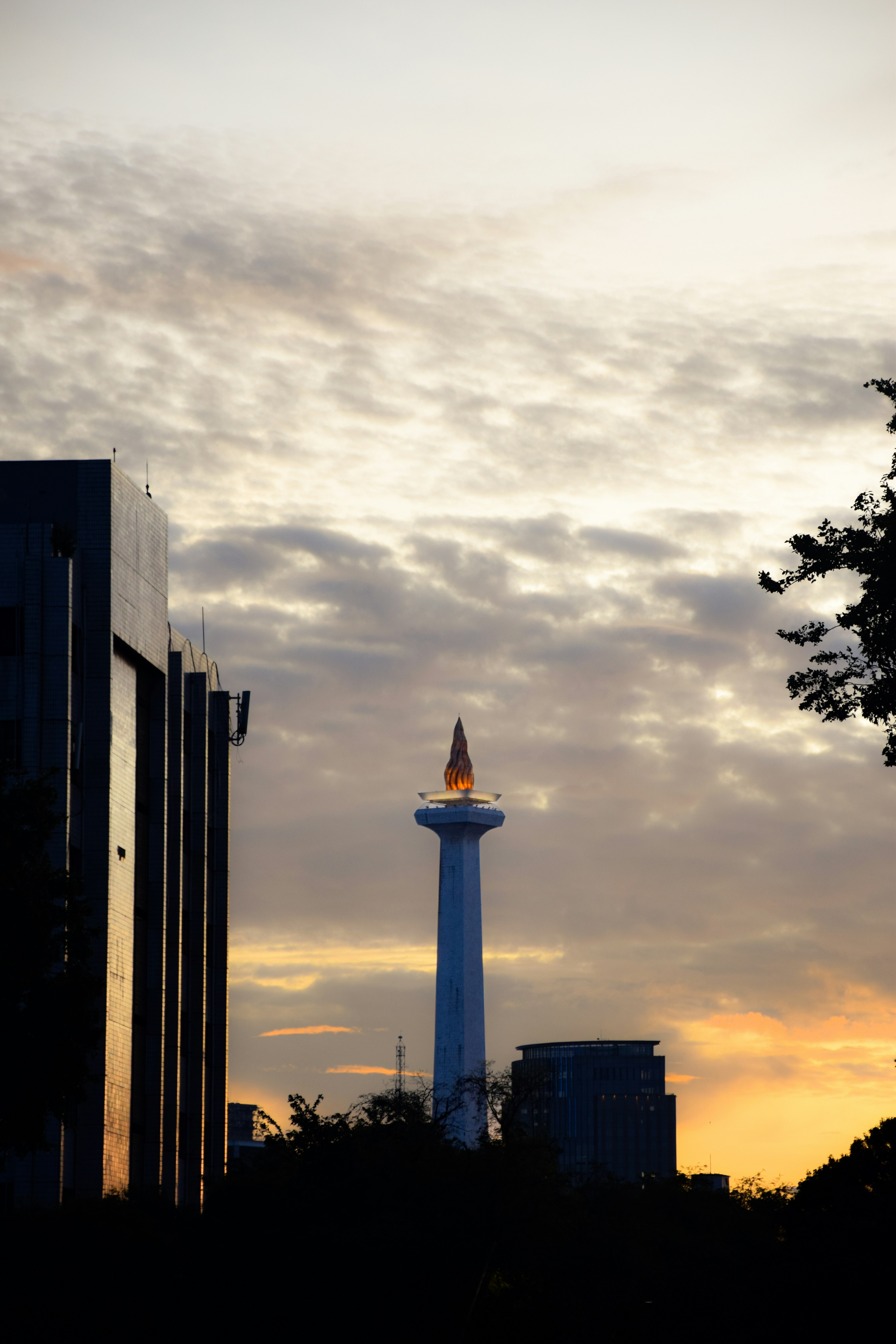 Tower Flame at Dusk: Urban Skyline with Fire-topped Monument