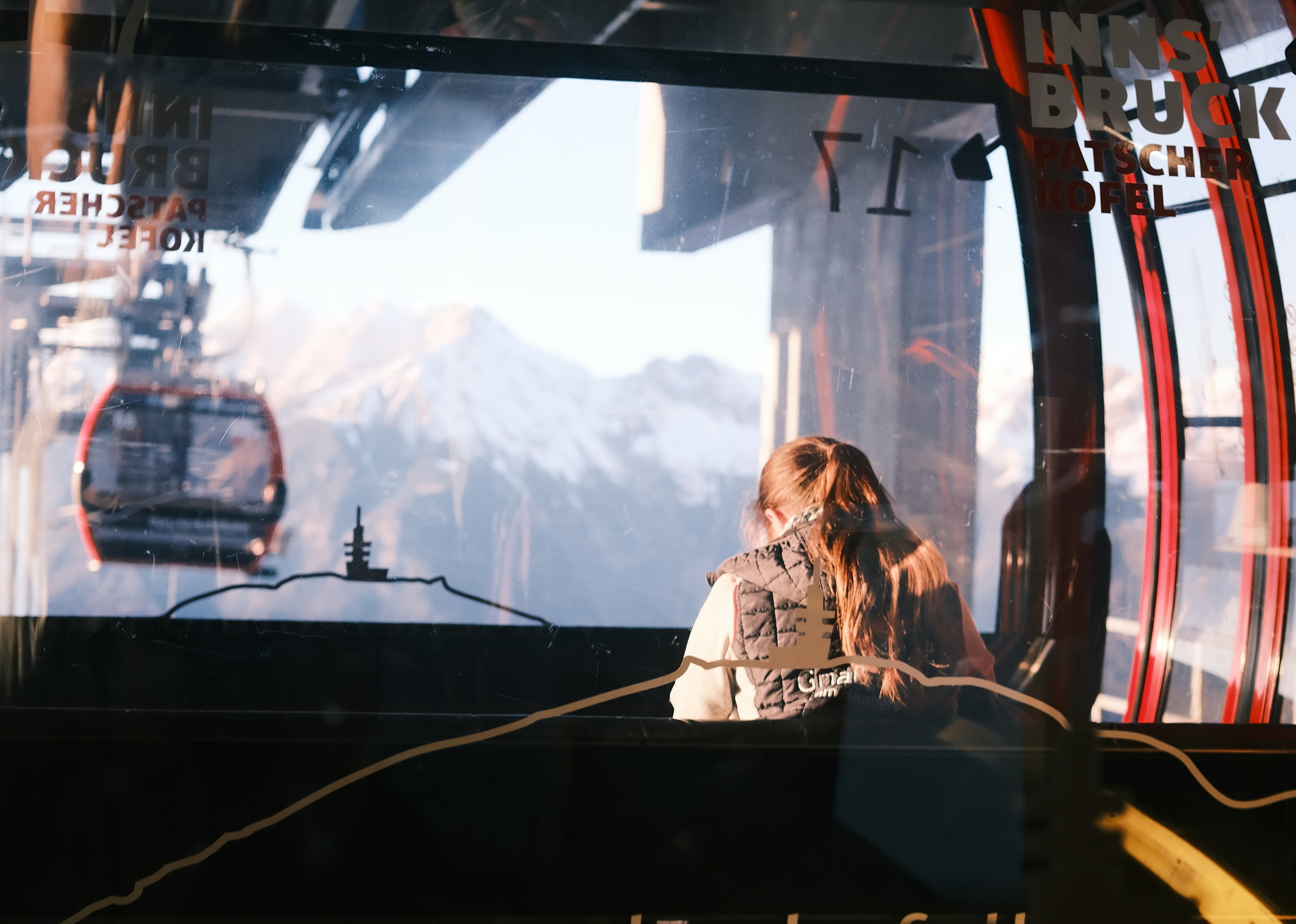 Down the Cable Car Window: Figures in a Mountain Gondola