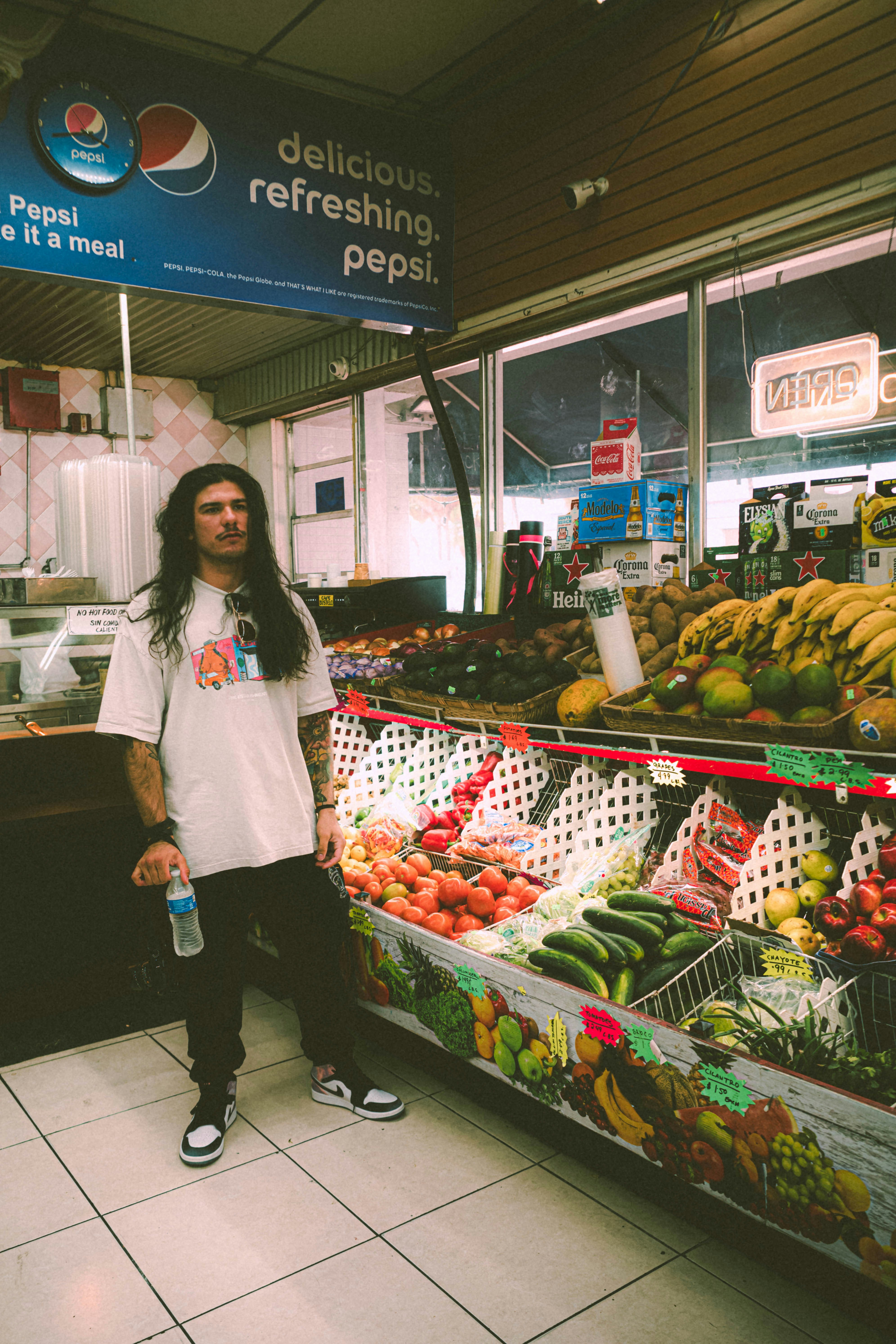 a man standing in front of a fruit stand