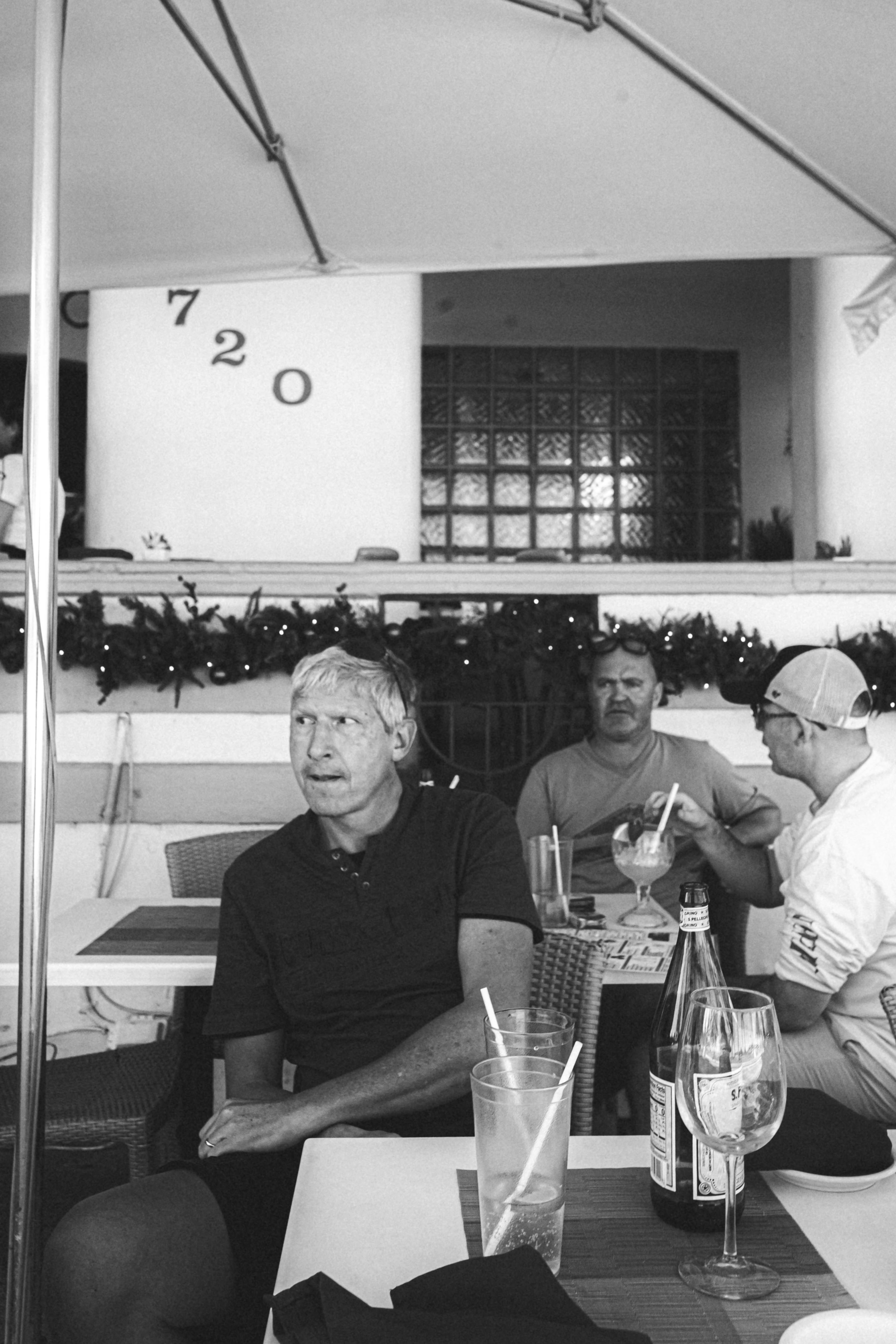 A group of men sitting at a table in a restaurant photo – Free Portrait ...
