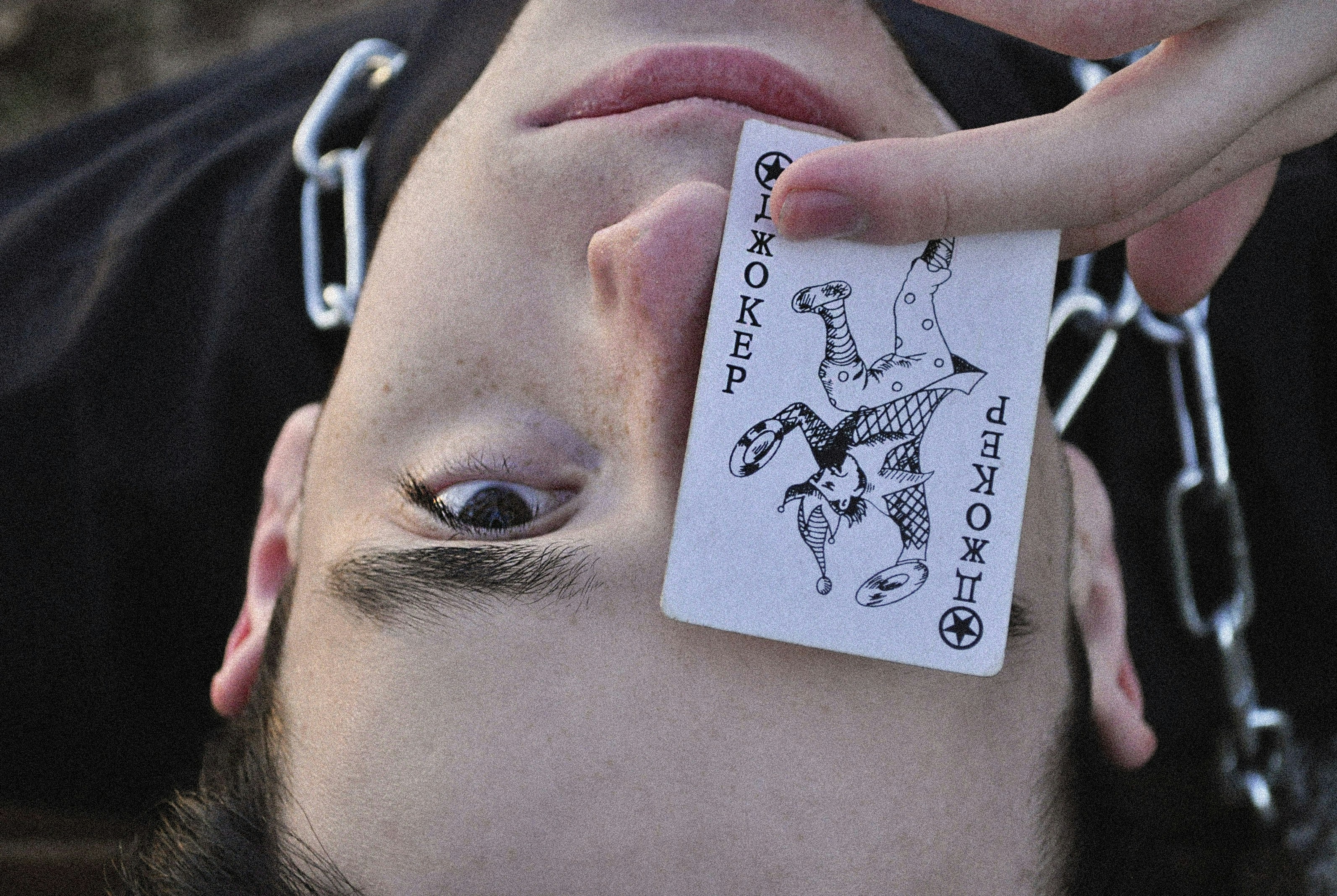 Joker at the Threshold: An Inverted Portrait with a Card in Focus