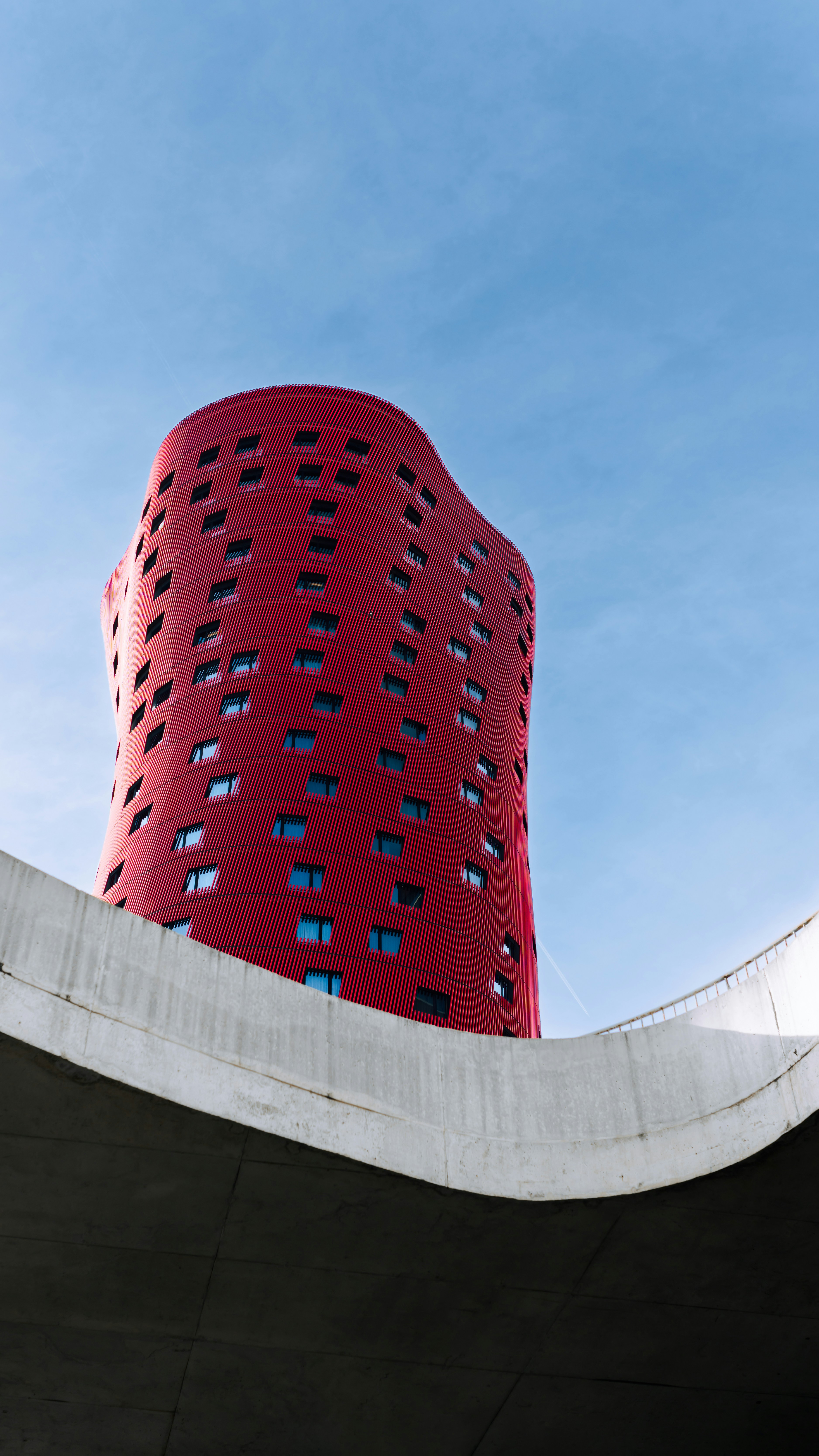 a tall red building sitting on the side of a bridge